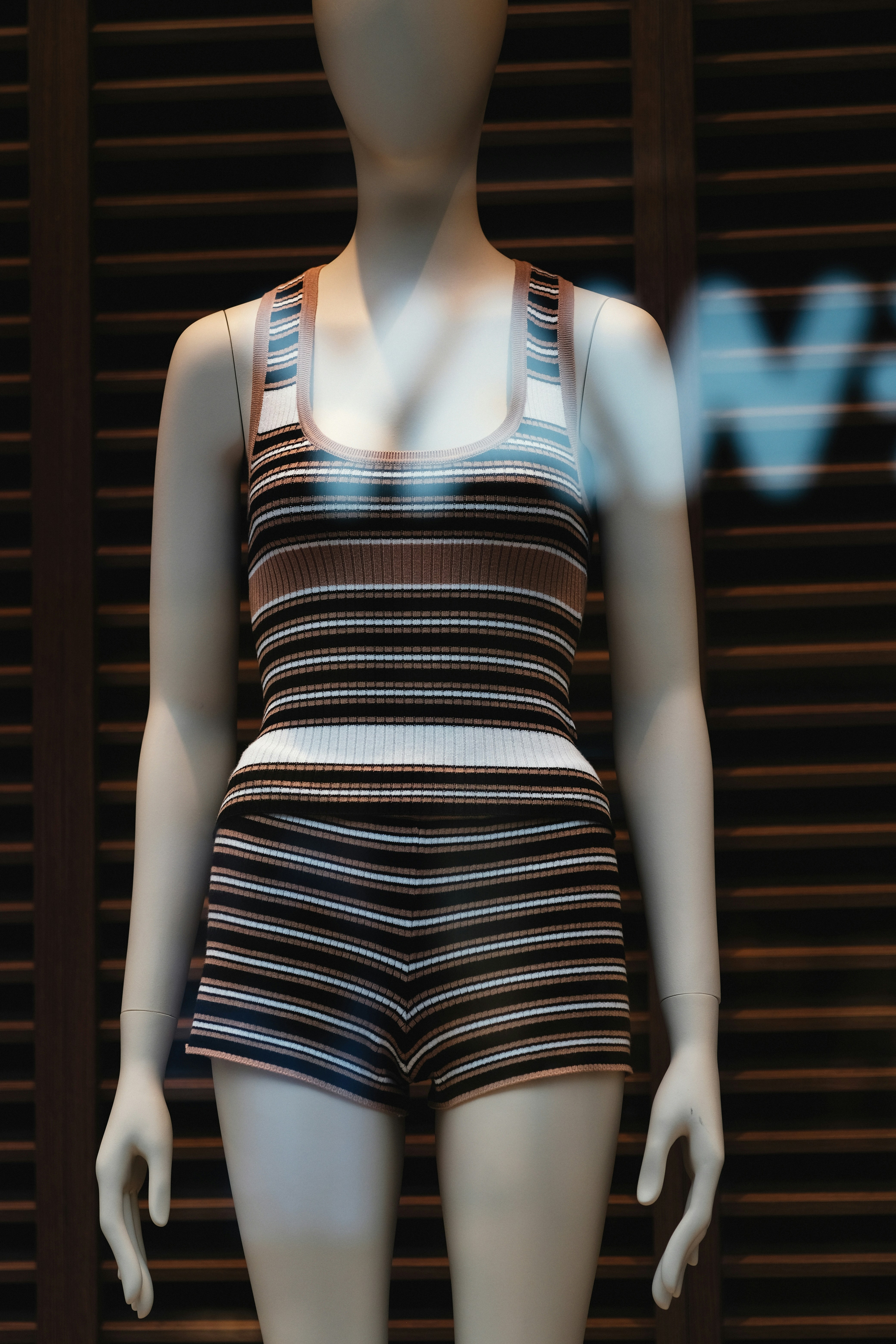 Striped sleeveless top and short set on a standing mannequin in a storefront display.