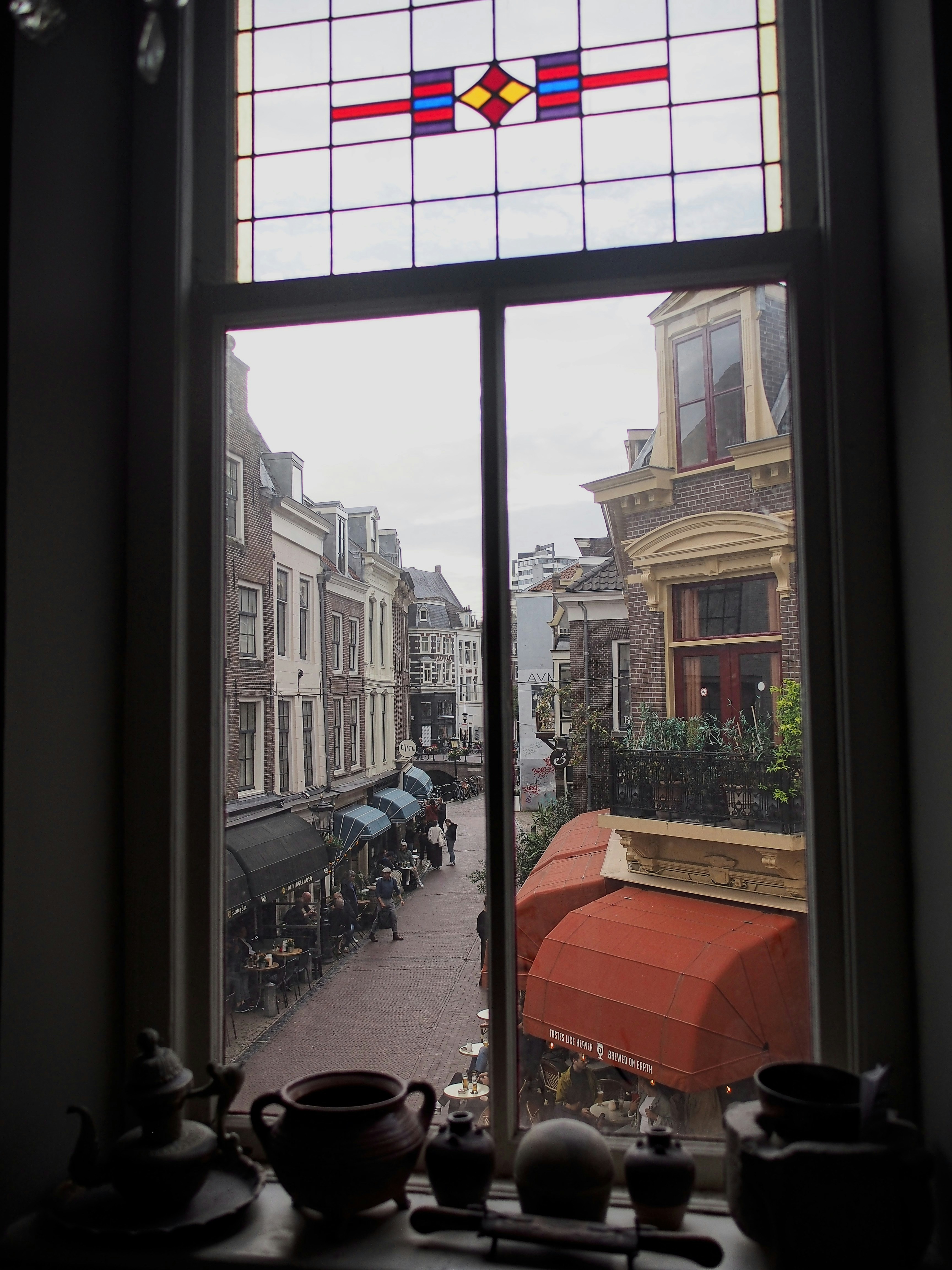 Through a Wrought-Glass View: A Quiet Street Café Beyond a Narrow Window