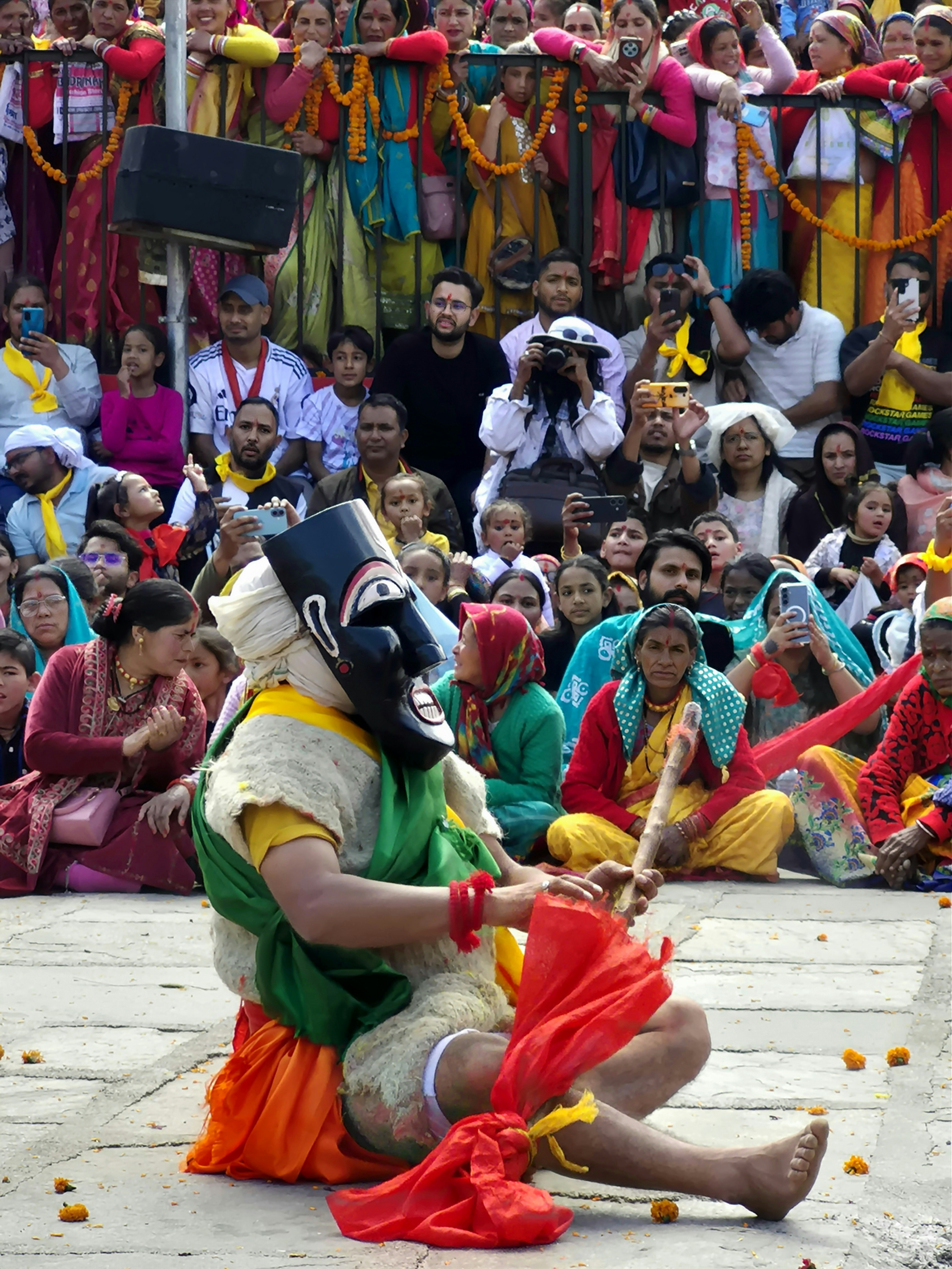 Masked dancer in a festive crowd unveils tradition amid cheers