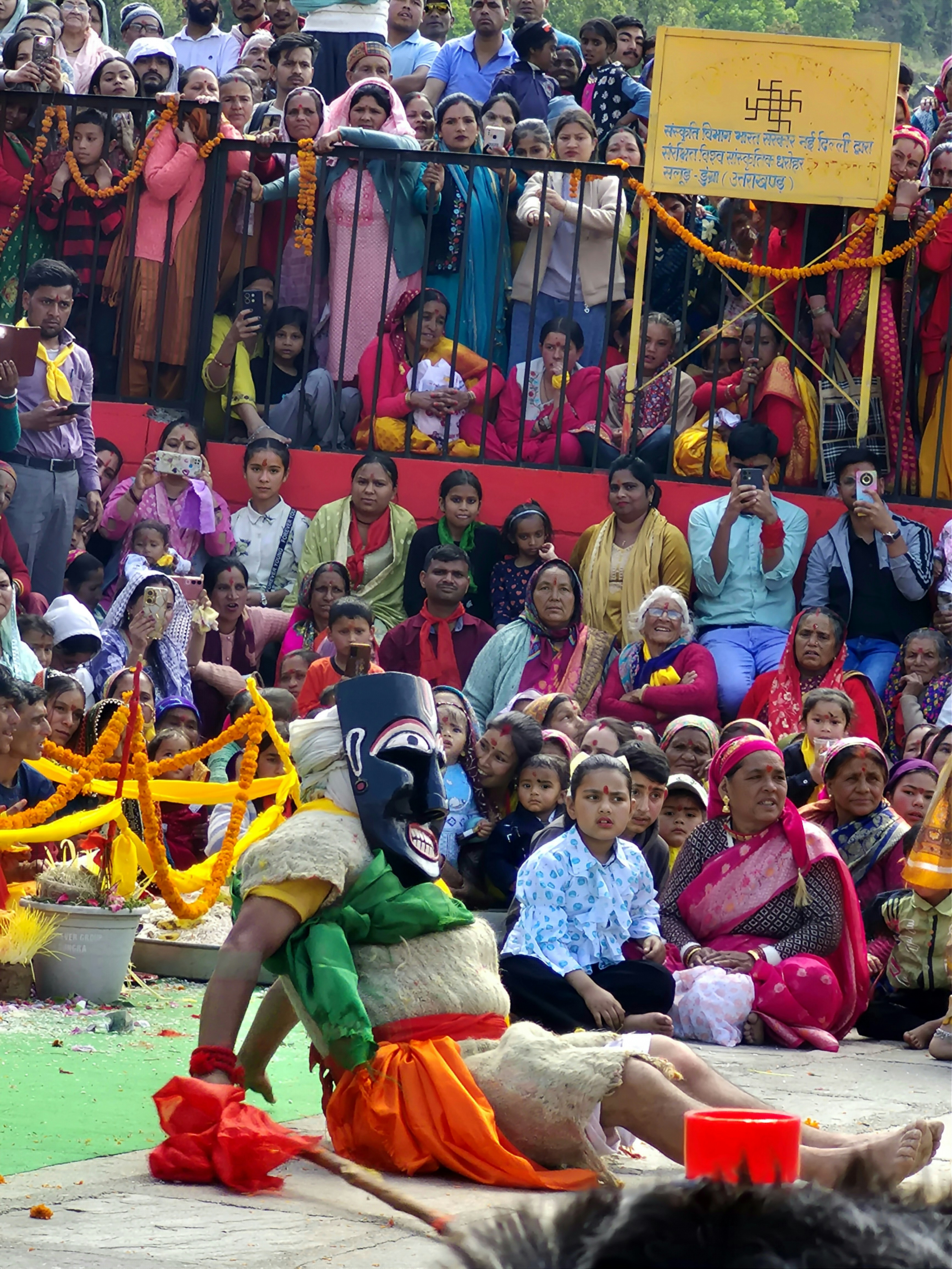 Masked dancer dwarves the crowd in a vibrant street performance