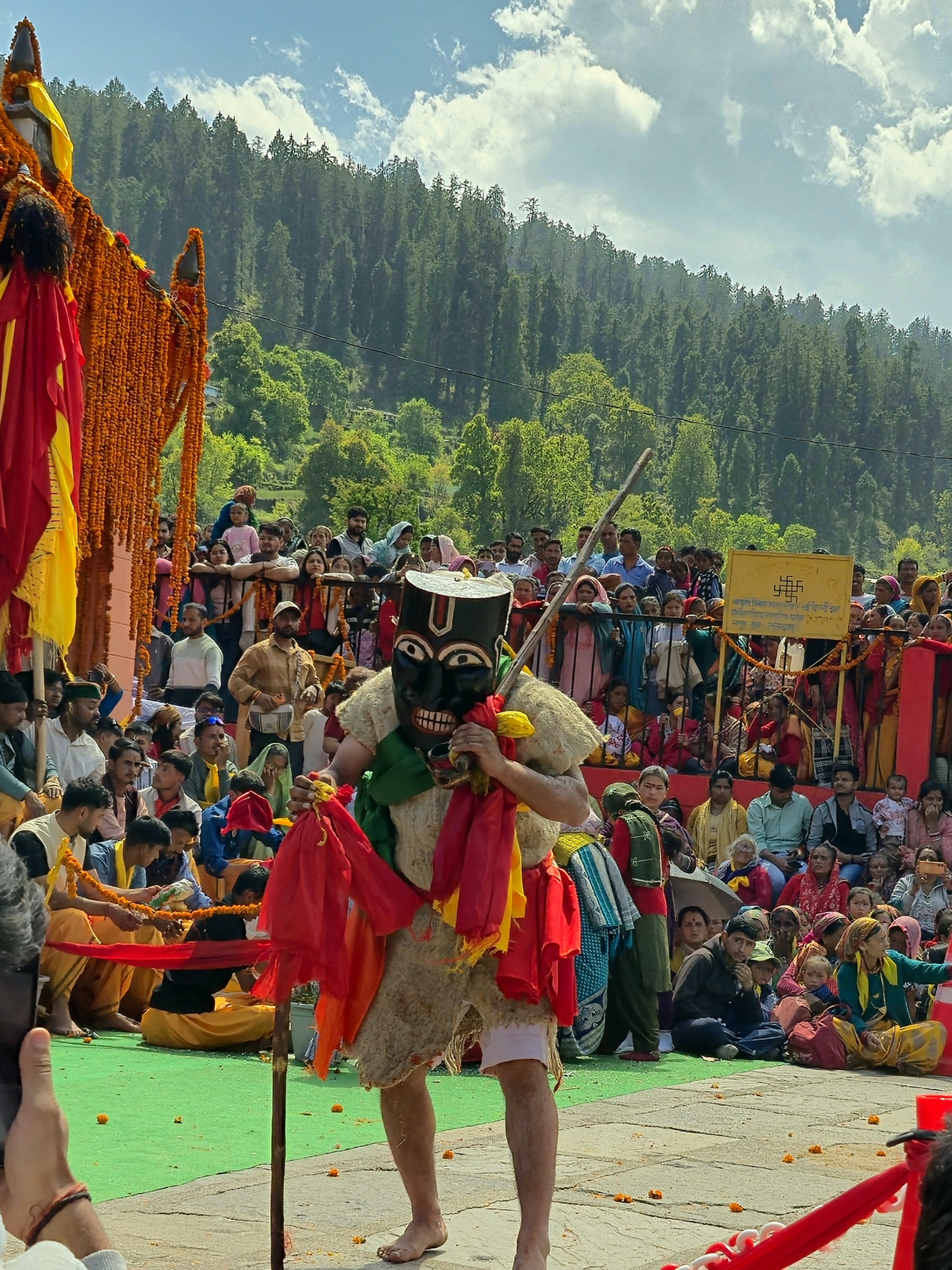 Masked Warrior Steps Forward in a Ceremonial Gathering