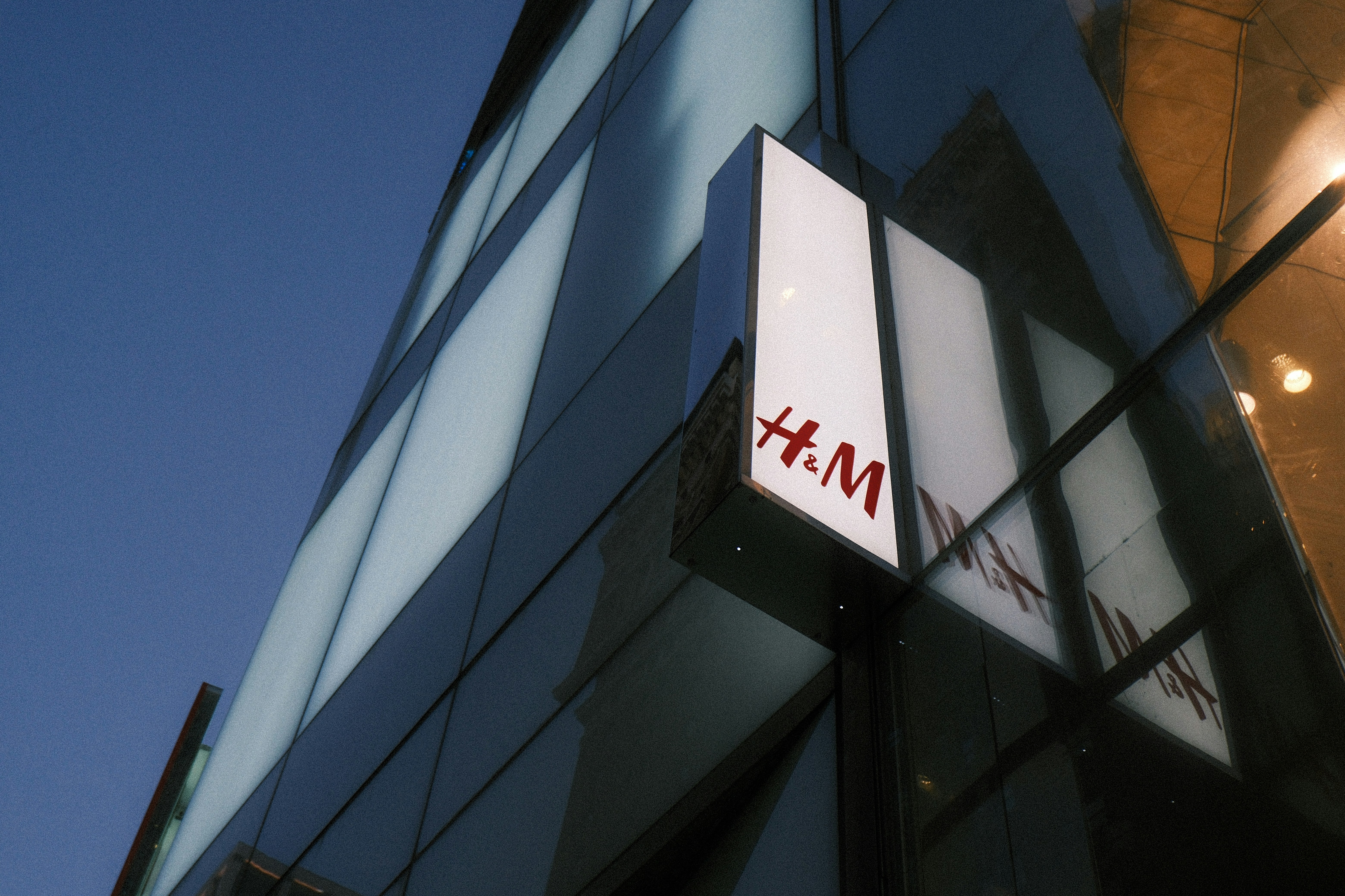 Glass Facade, Red H&M Logo, Evening Light Over Urban Glasswork