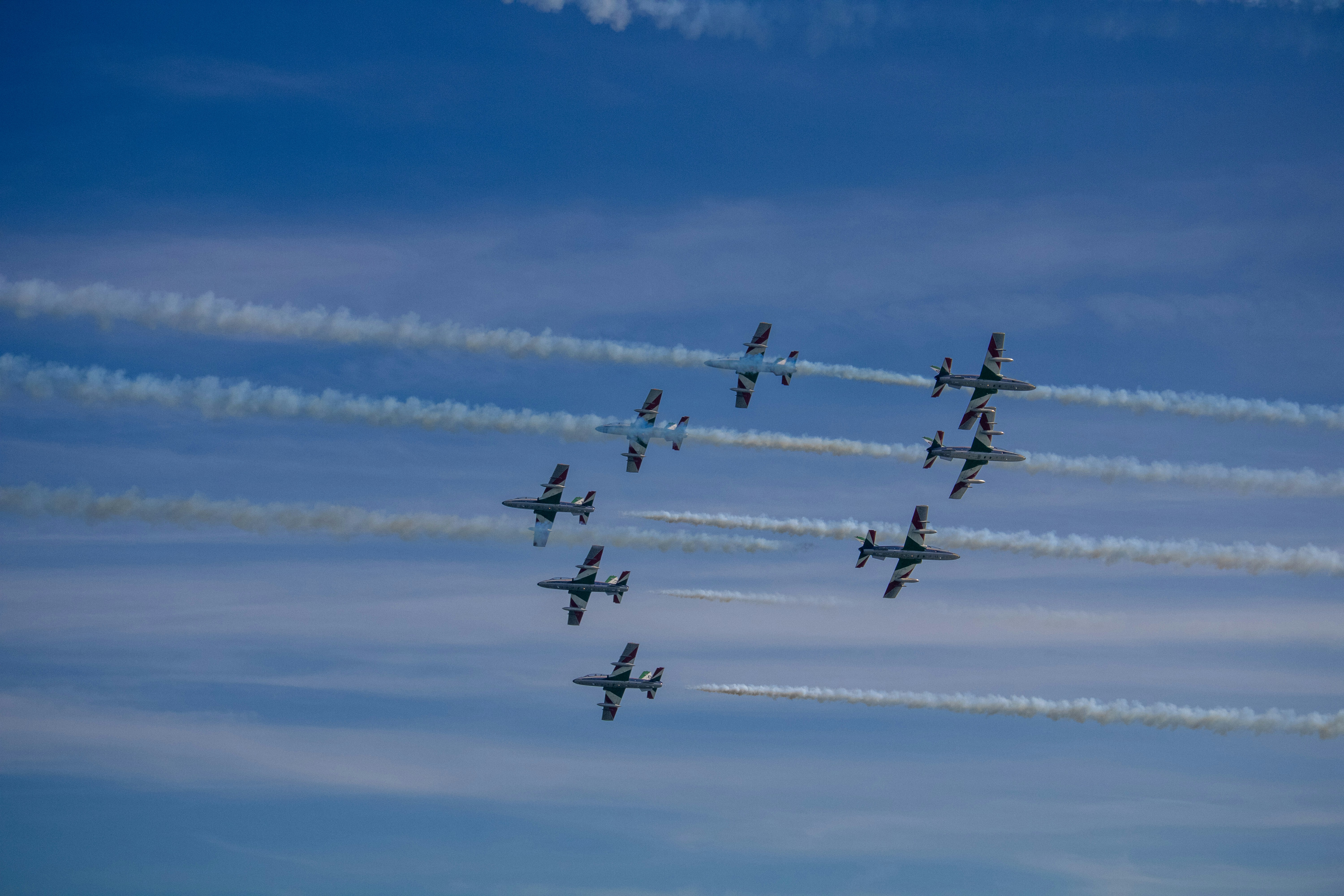 Skyward Chorus: A Formation of Aerobatics Traces White Vapor Lines