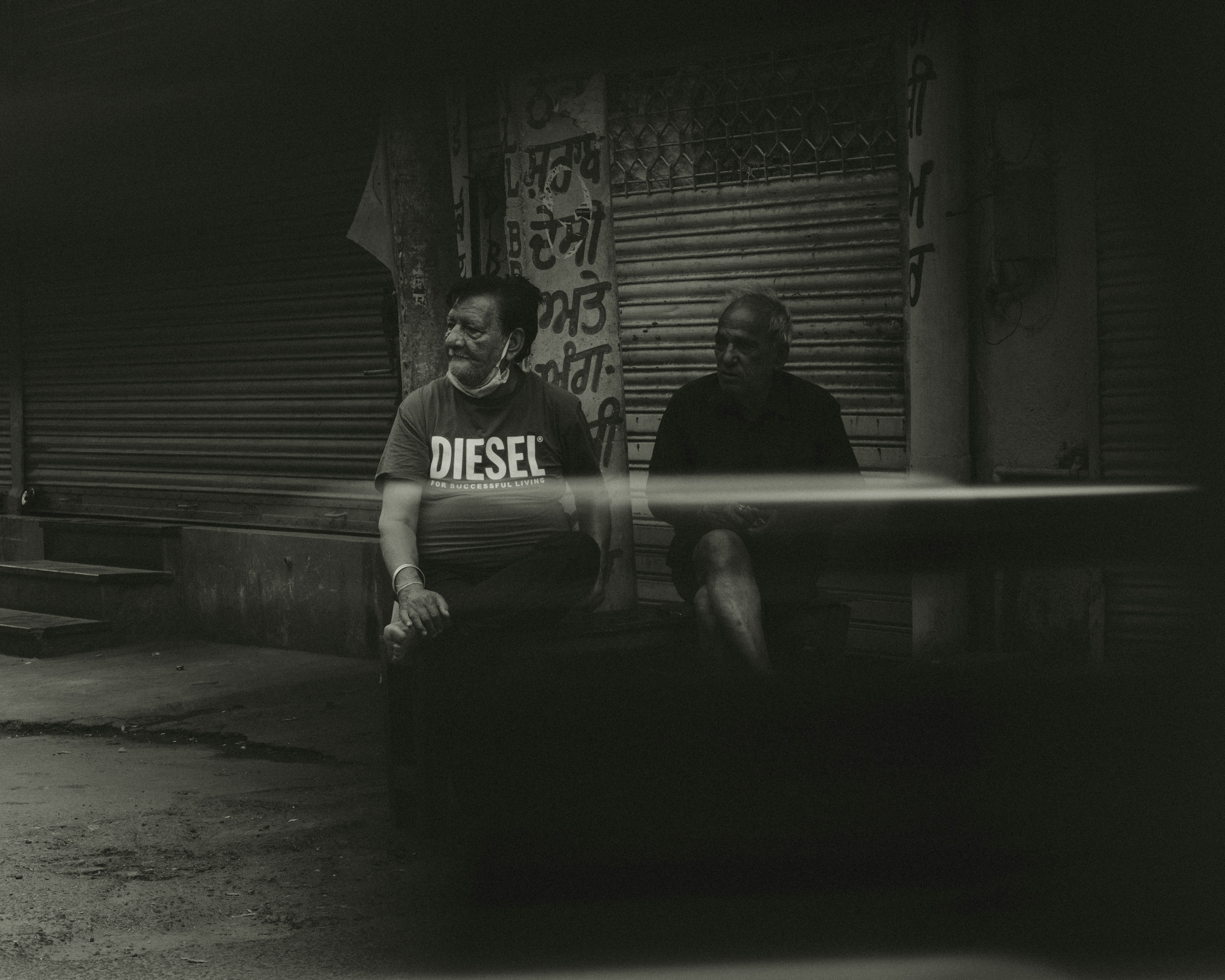 Two Men on a Shadowed Street Bench in a Quiet Moment
