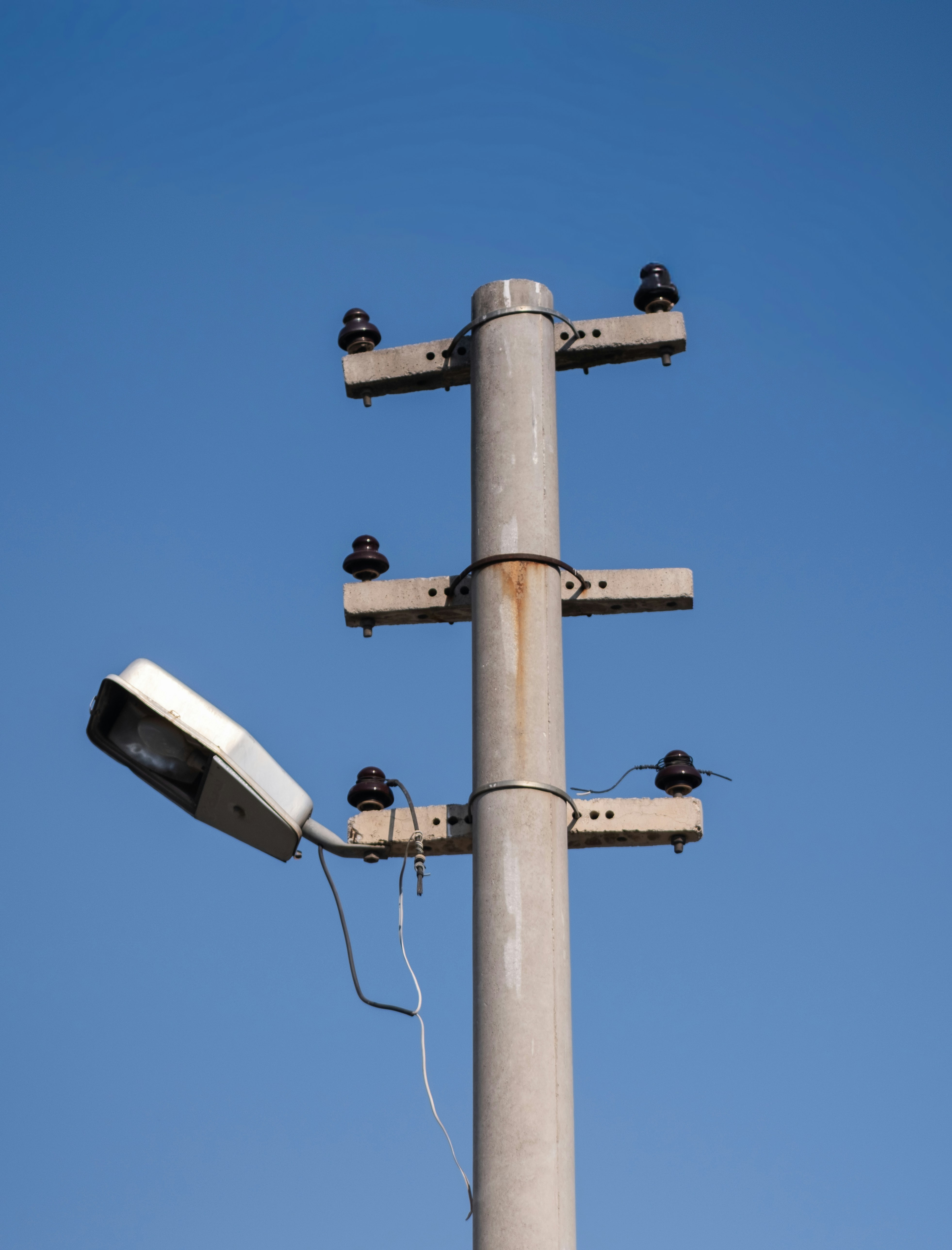Pole of Light: A lone street lamp against a clear blue sky