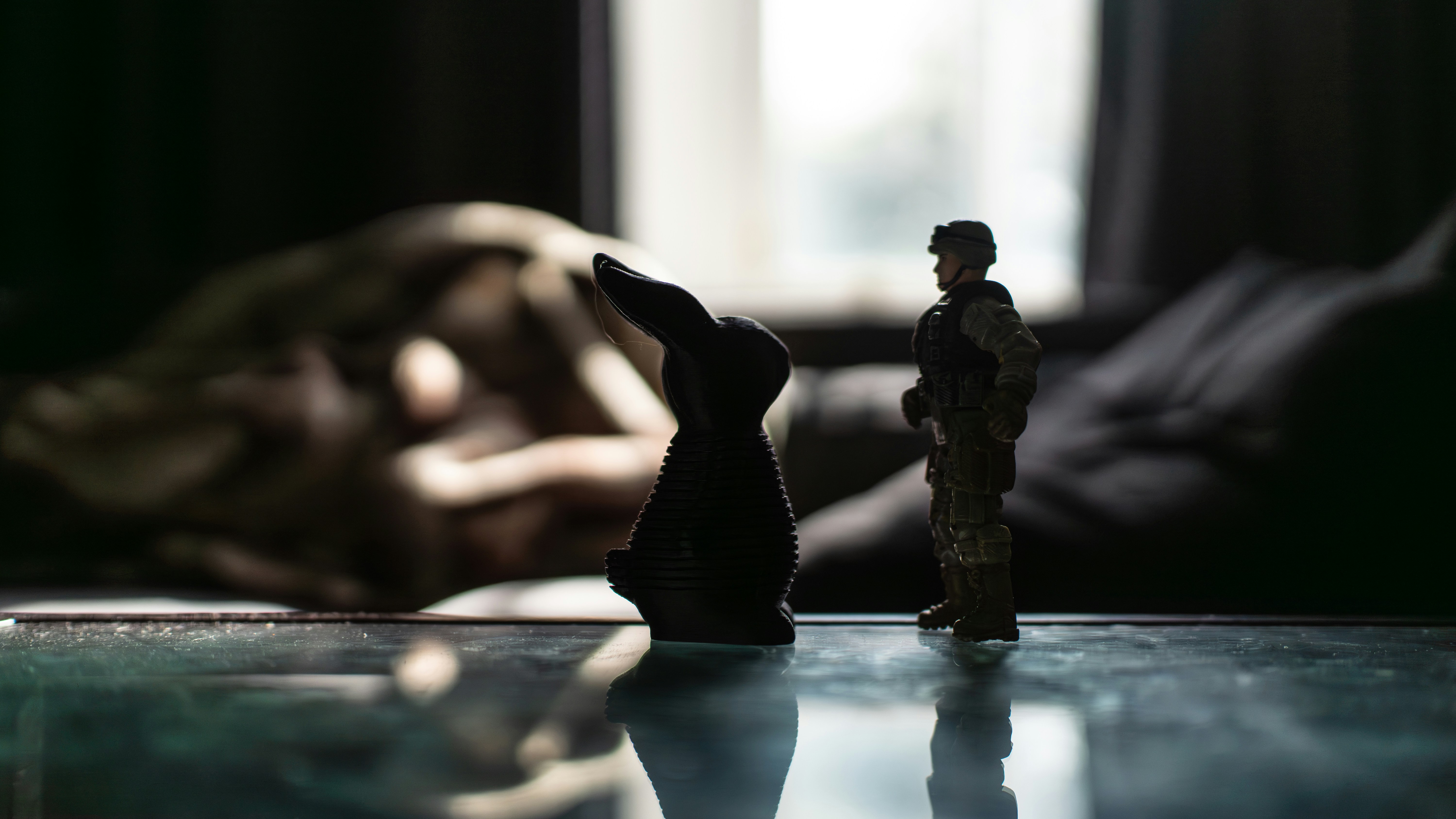 Chocolate bunny and toy soldier on a reflective surface.