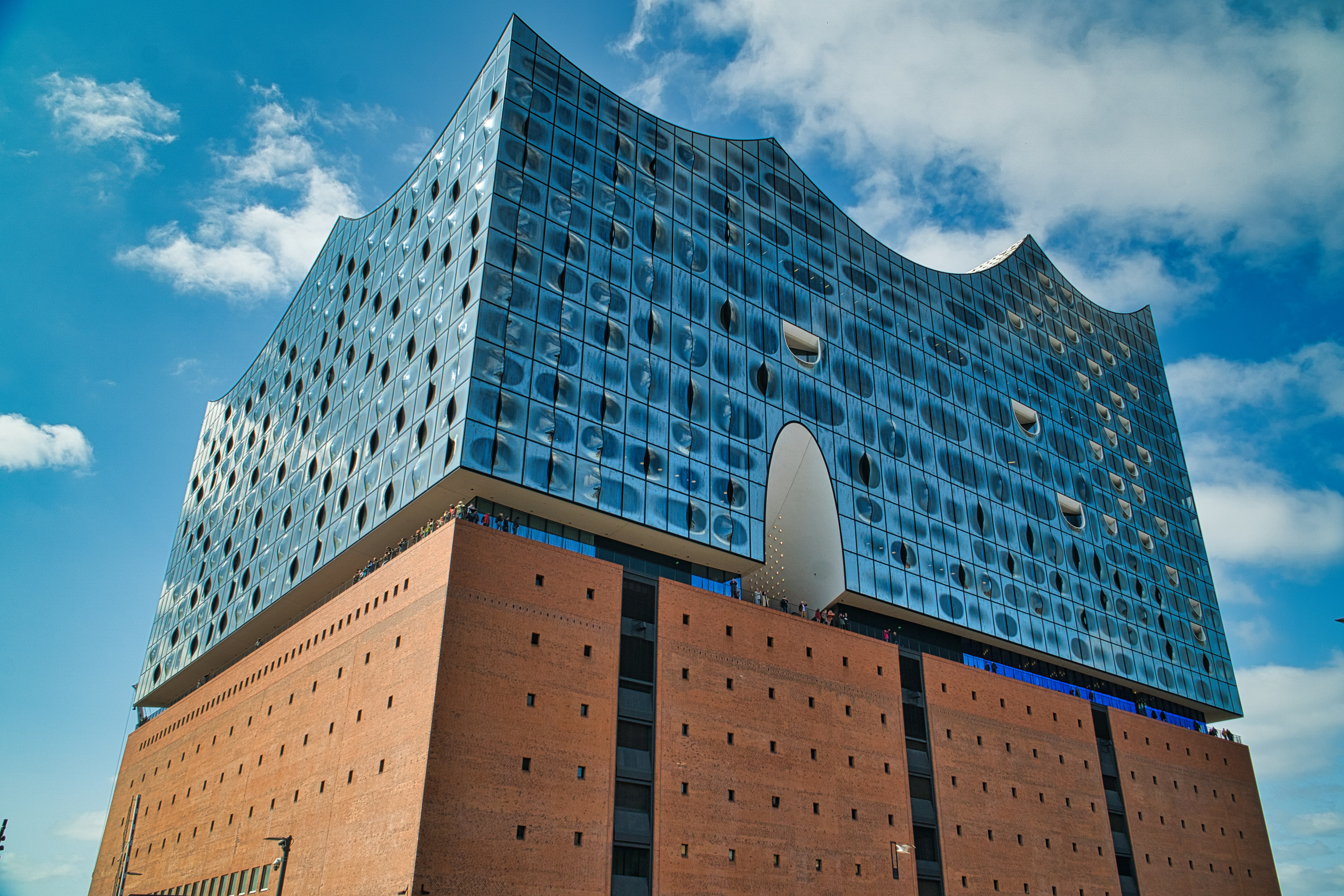 Arching Echoes: The curved blue façade above the brick pedestal