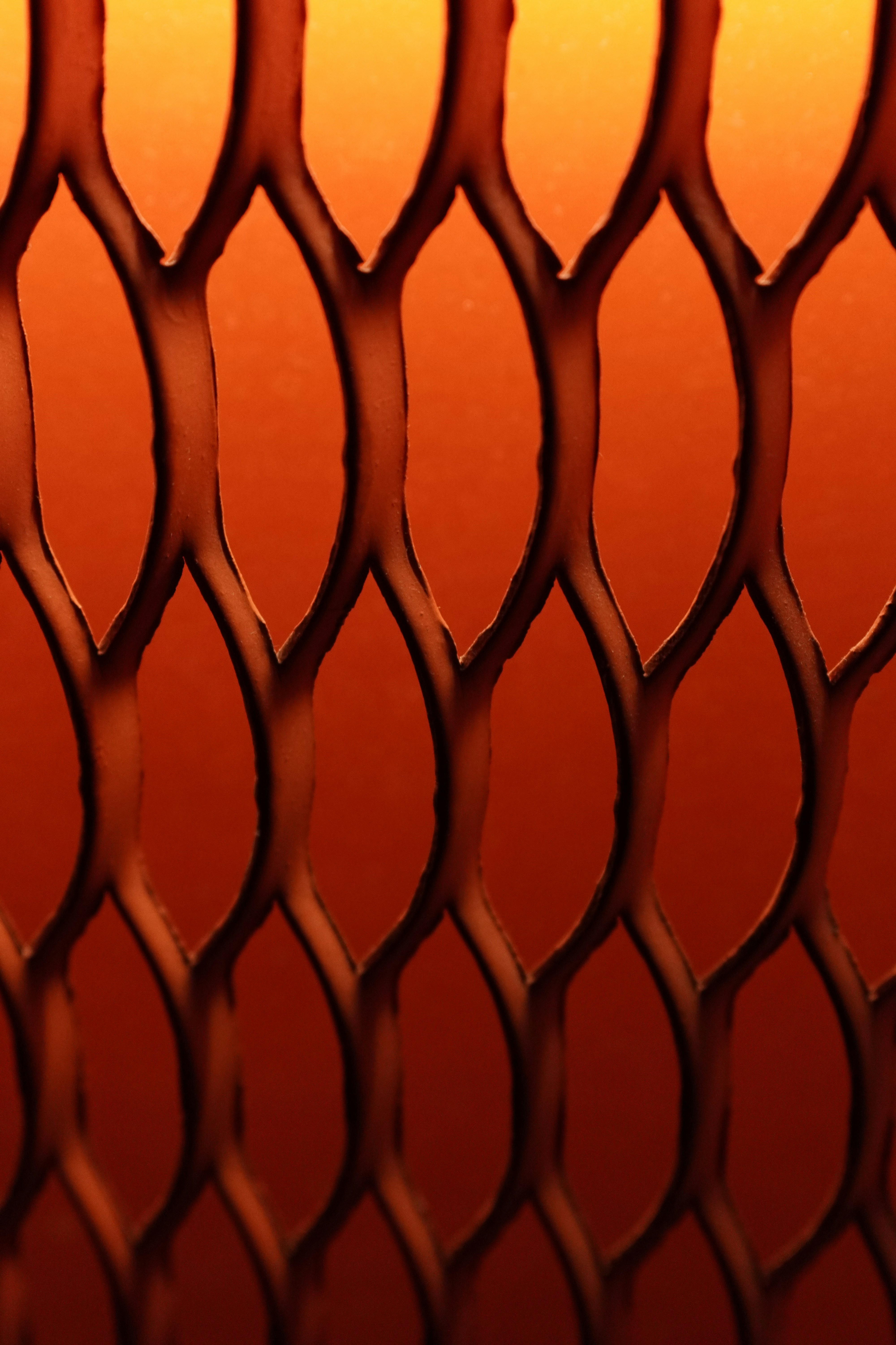 Crimson Mesh: A Close-Up of Woven Steel in Warm Light
