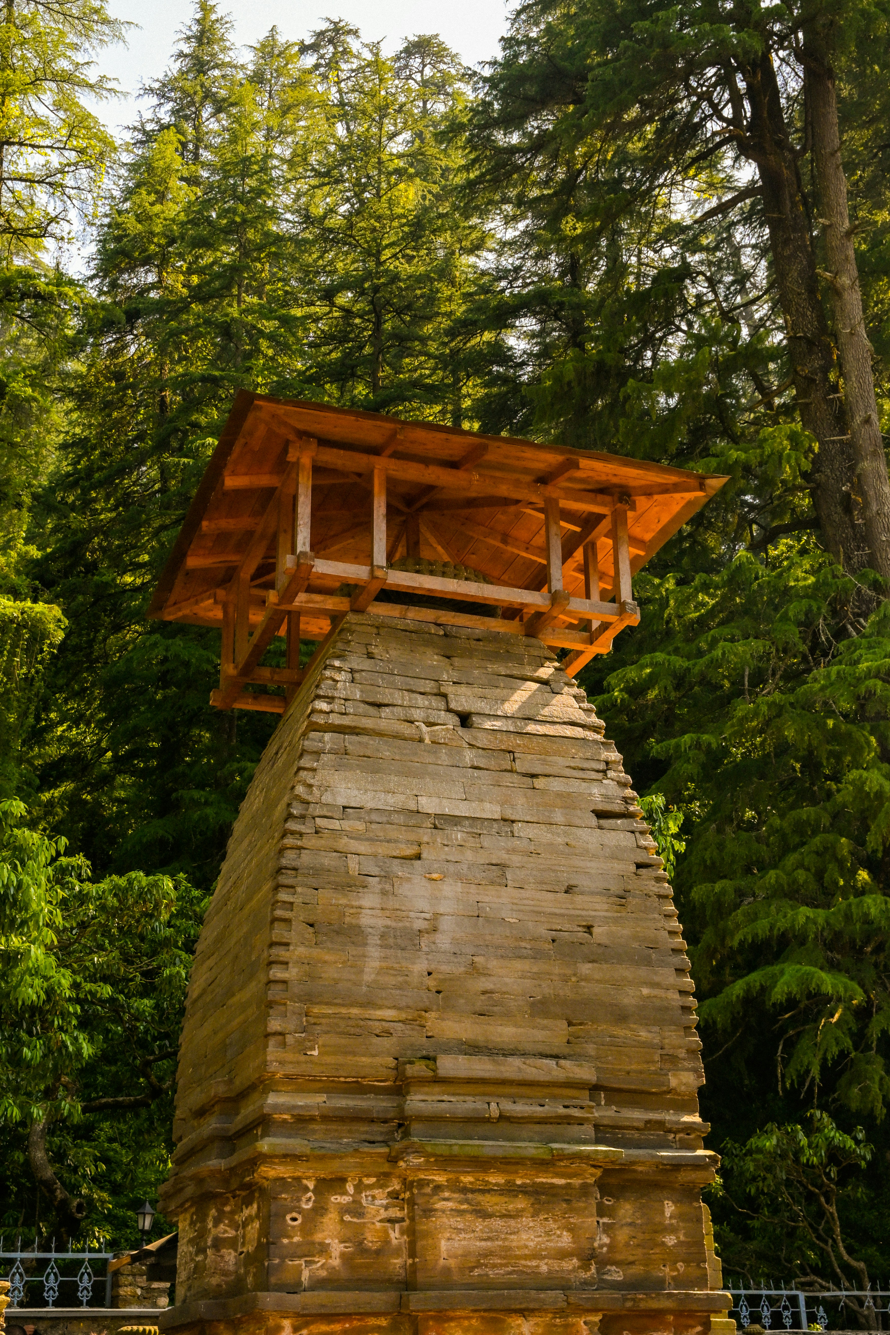 Timbered Gatekeepers: A Stone Pillar Rising Toward a Timbered Platform