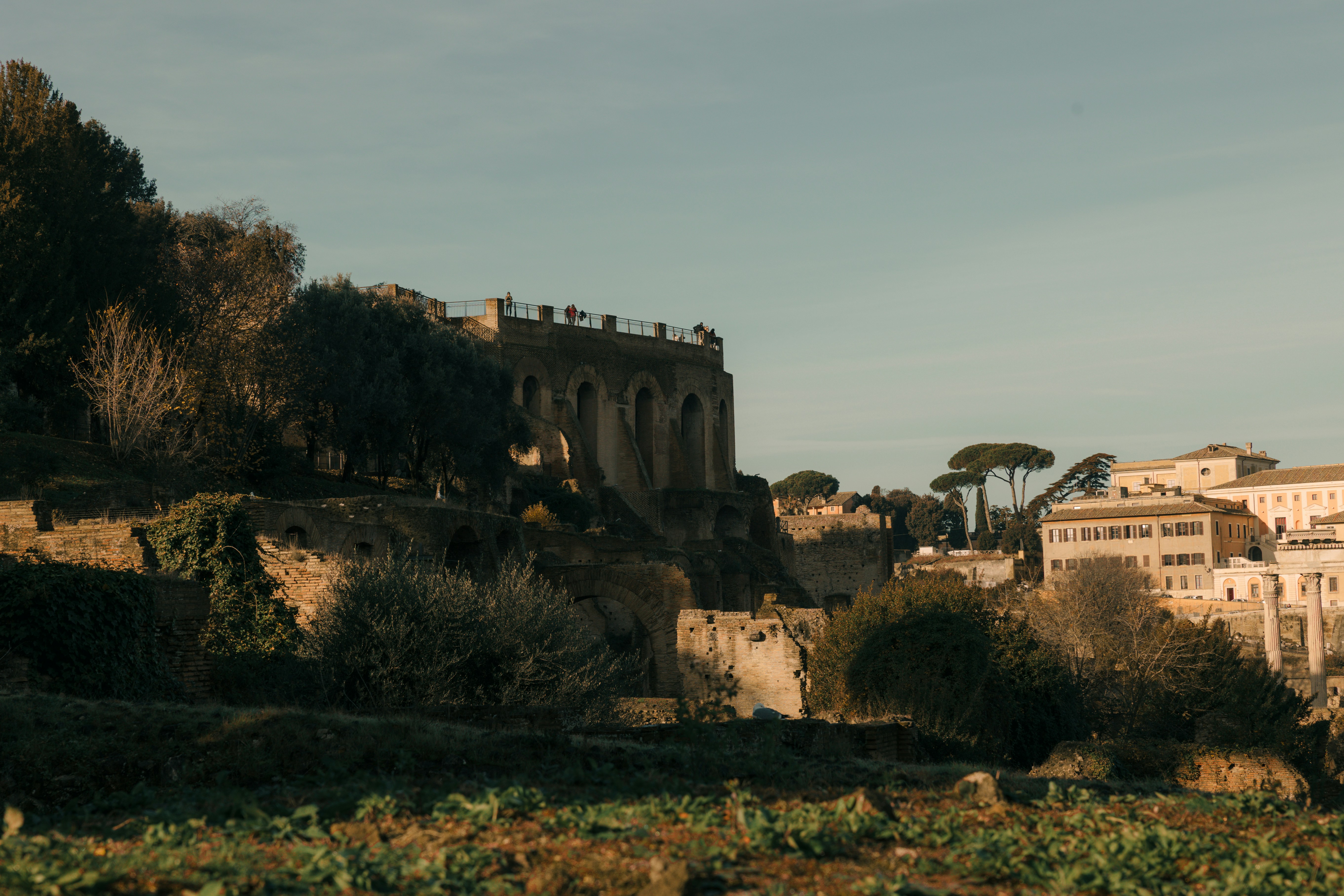An ancient building on a hill overlooking a distant town.