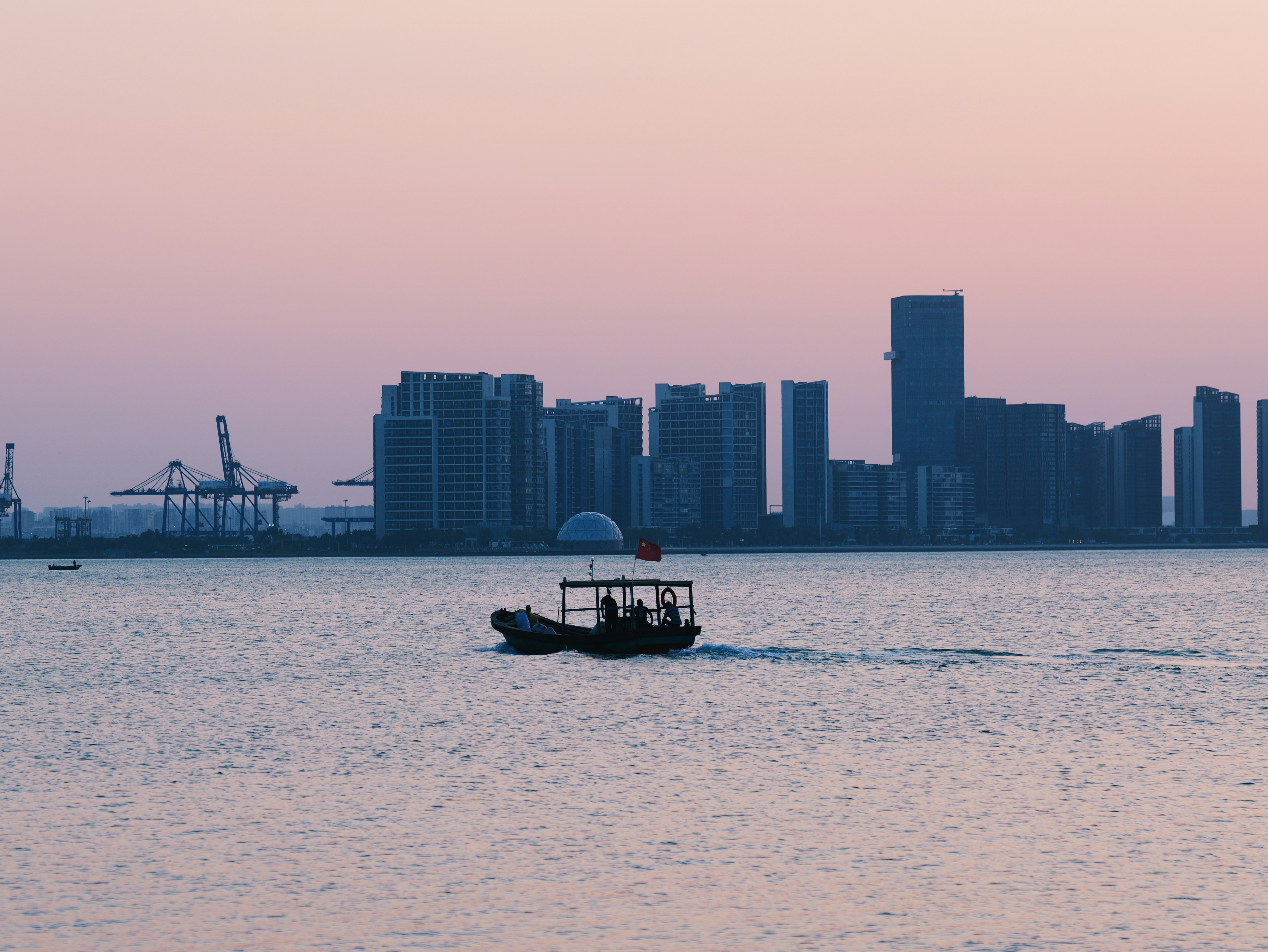 Silenced Horizon: Boat Skims the Quiet Bay Under a Pink-Orange Dusk