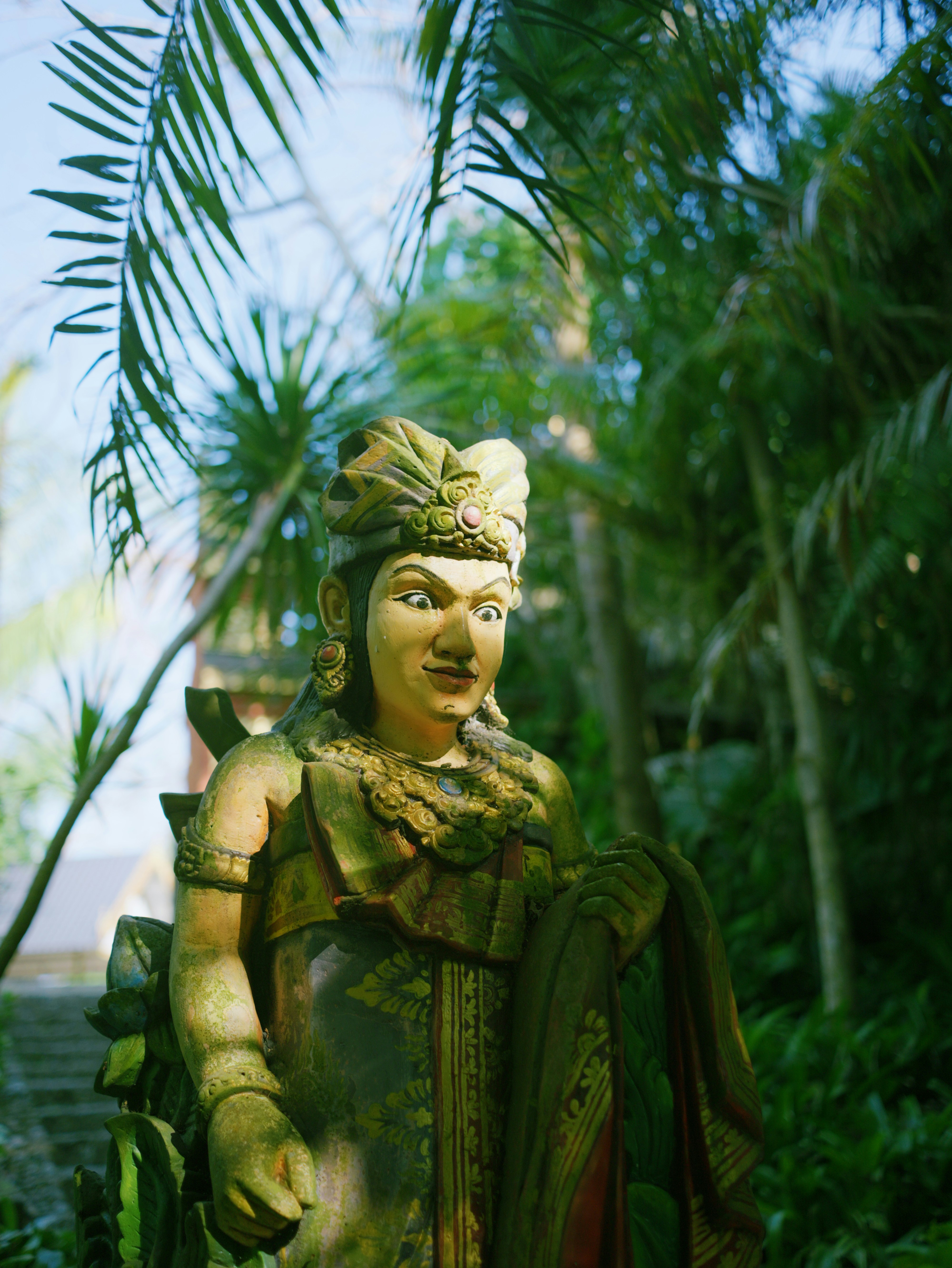 Golden Guardian: a serene statue amid tropical greens