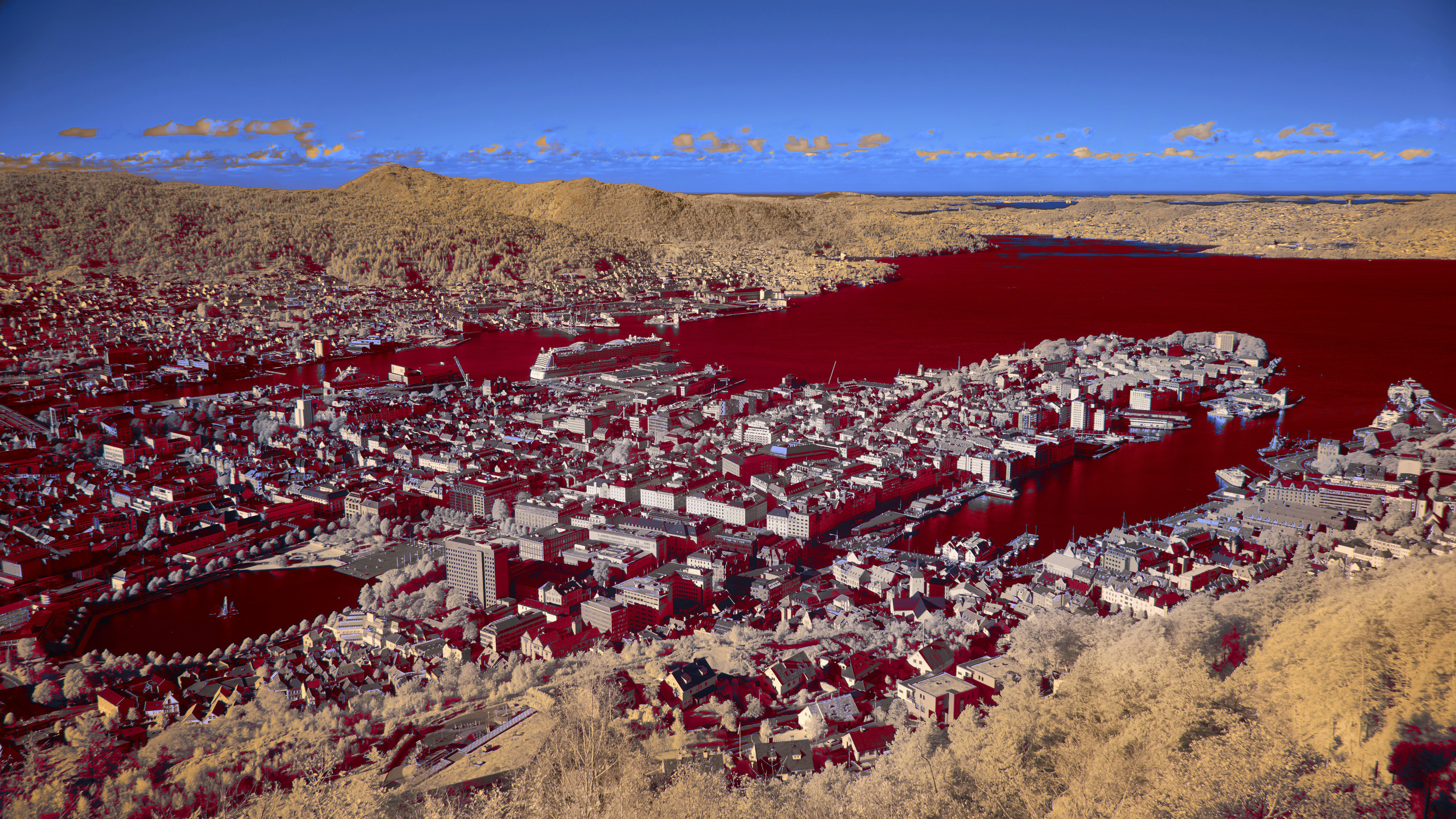 Red Valley Cityscape: Aerial Labyrinth Rising from a Desert Rim