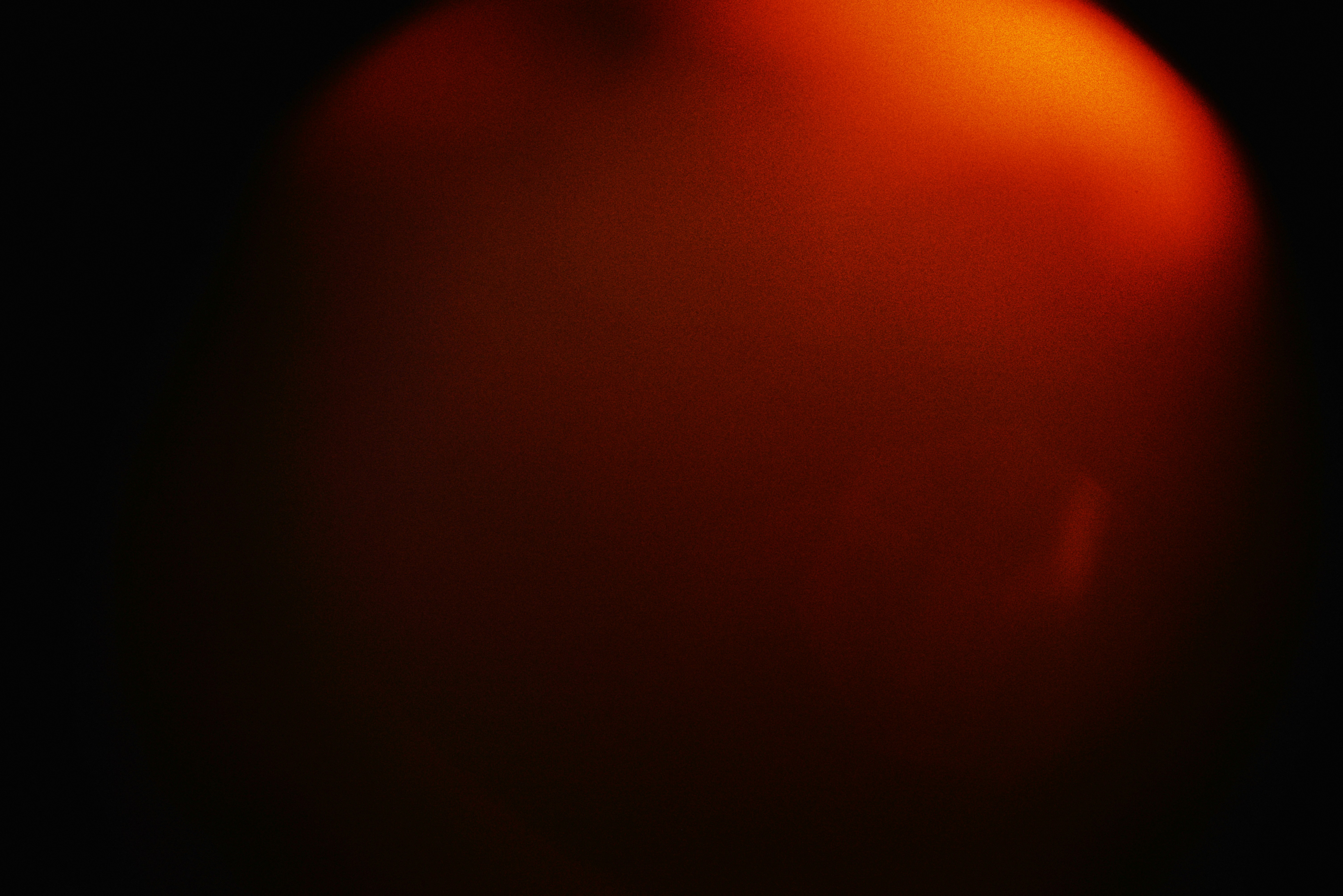 Amber Orb in Darkness: A Blurred Lunar Glow