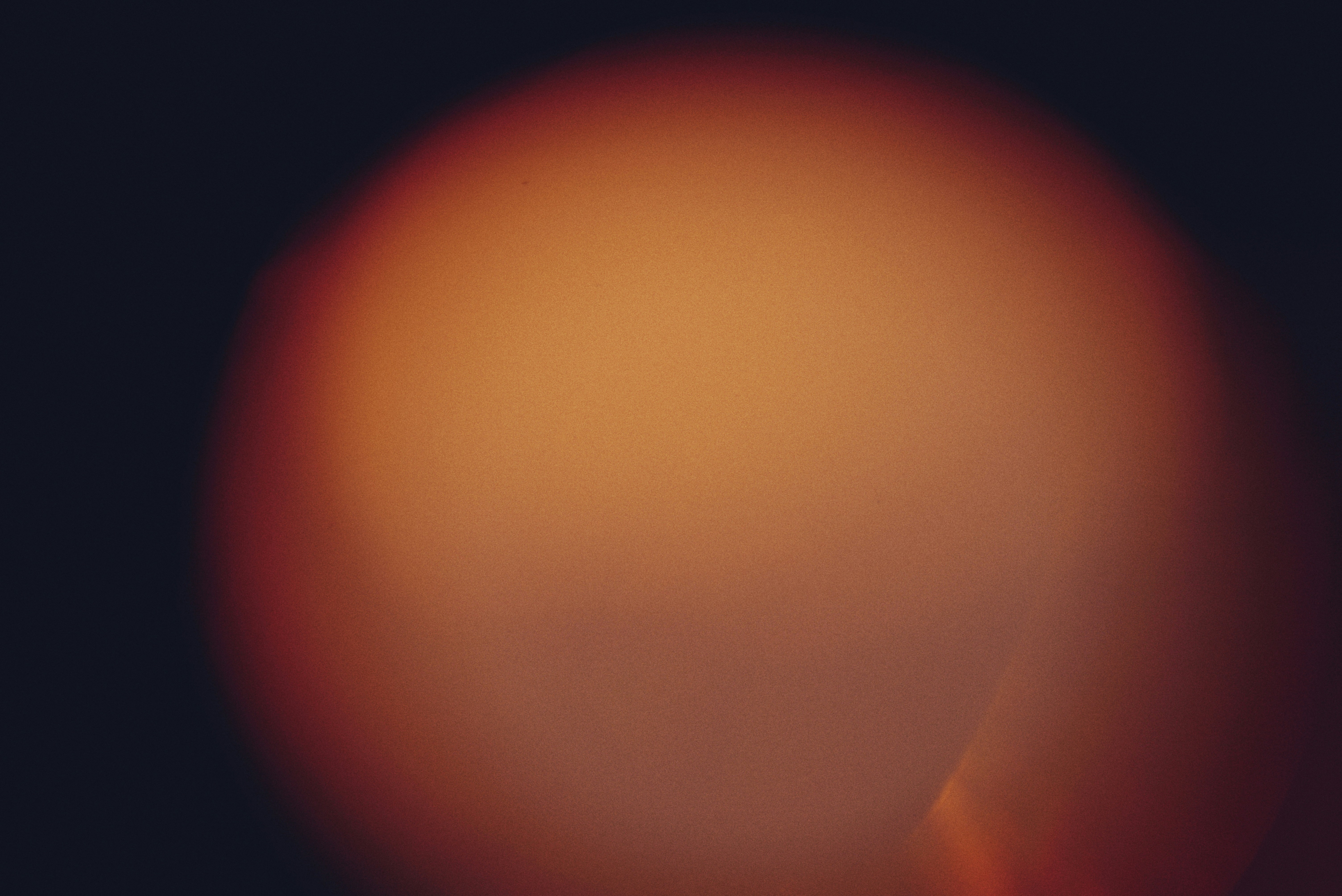 Soft ember: an abstract glow of orange on dark canvas