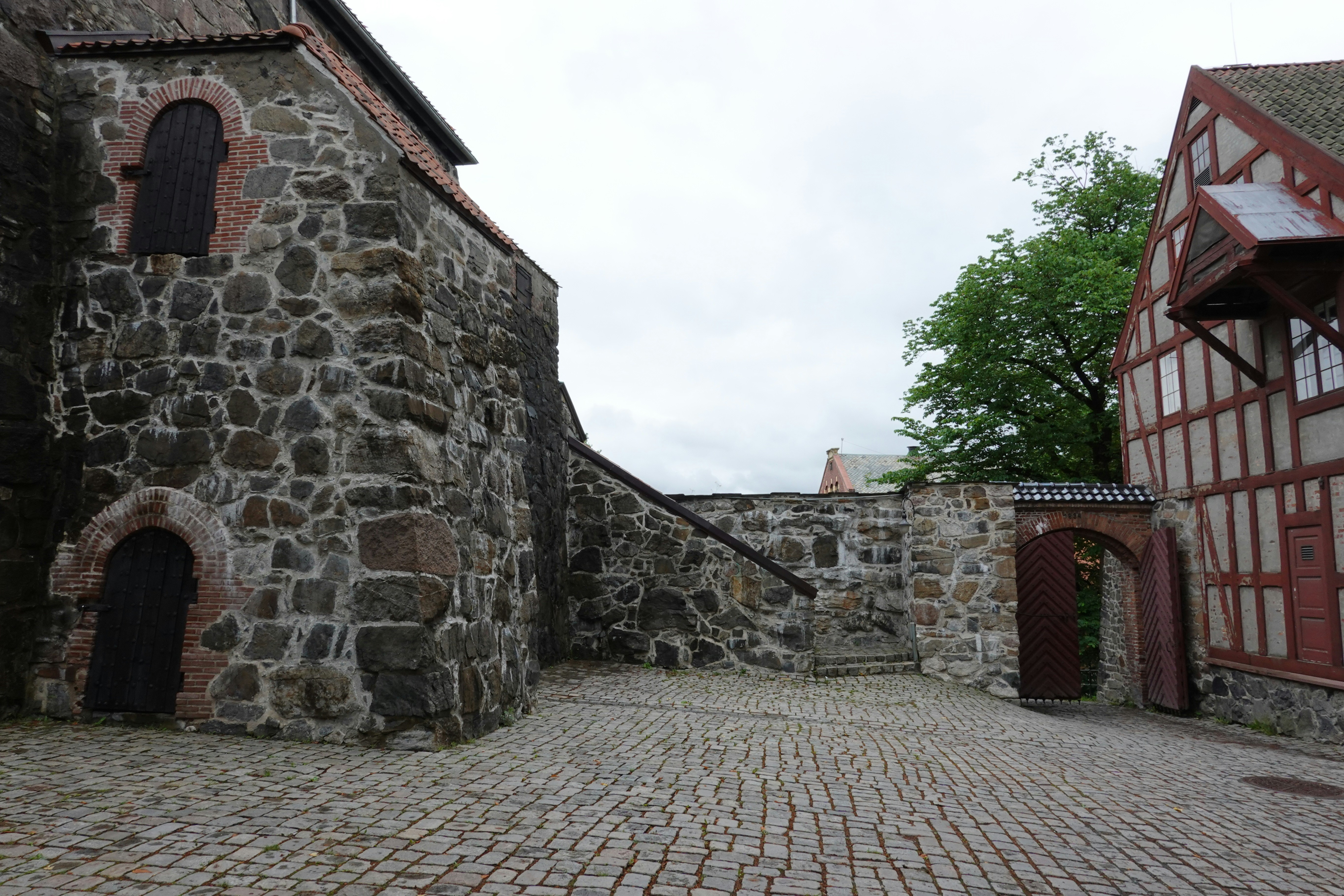 Cobblestone Courtyard Between Castle Wall and Timber-Framed Building
