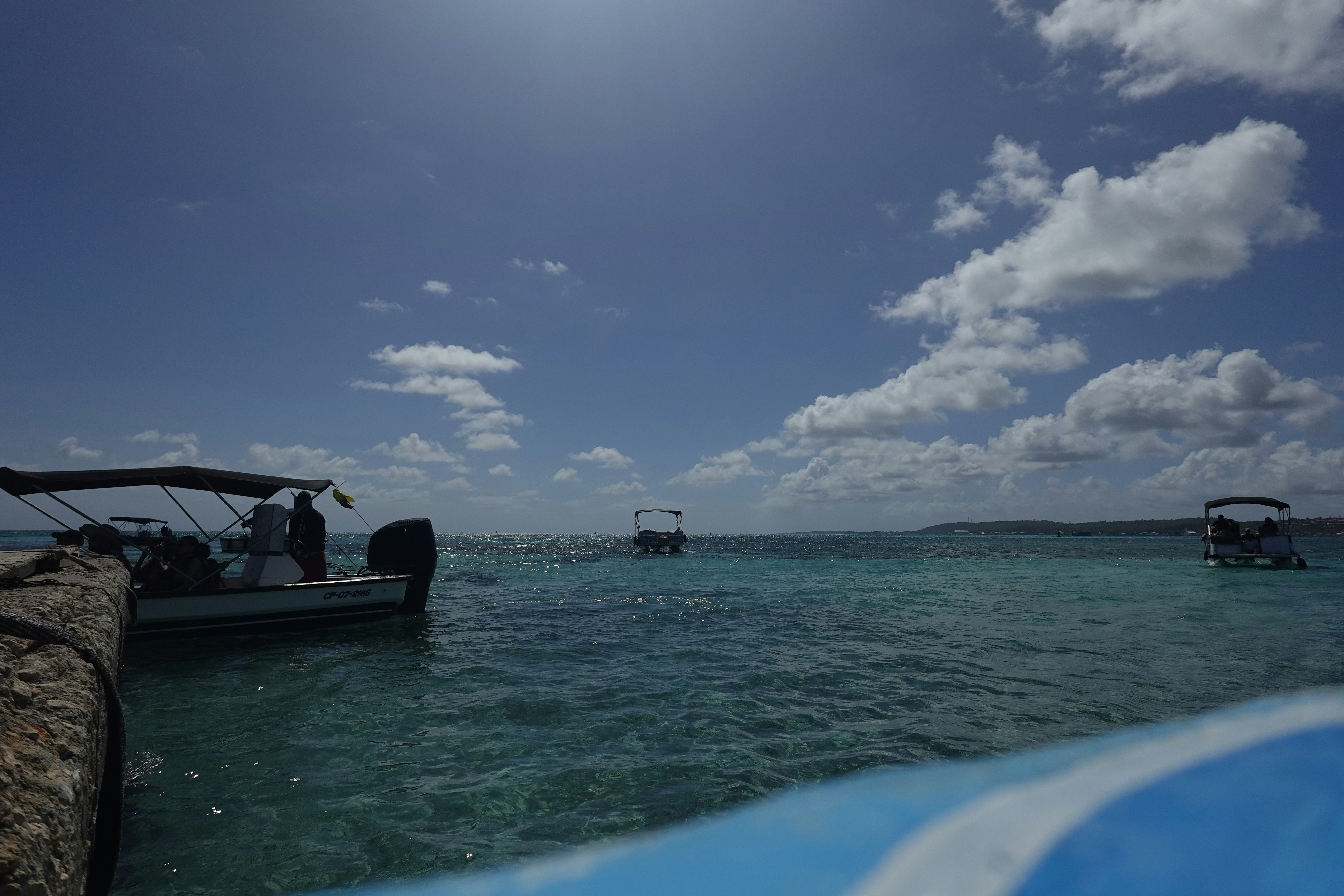 Blue Horizon: Boats Linger Near a Calm Sea