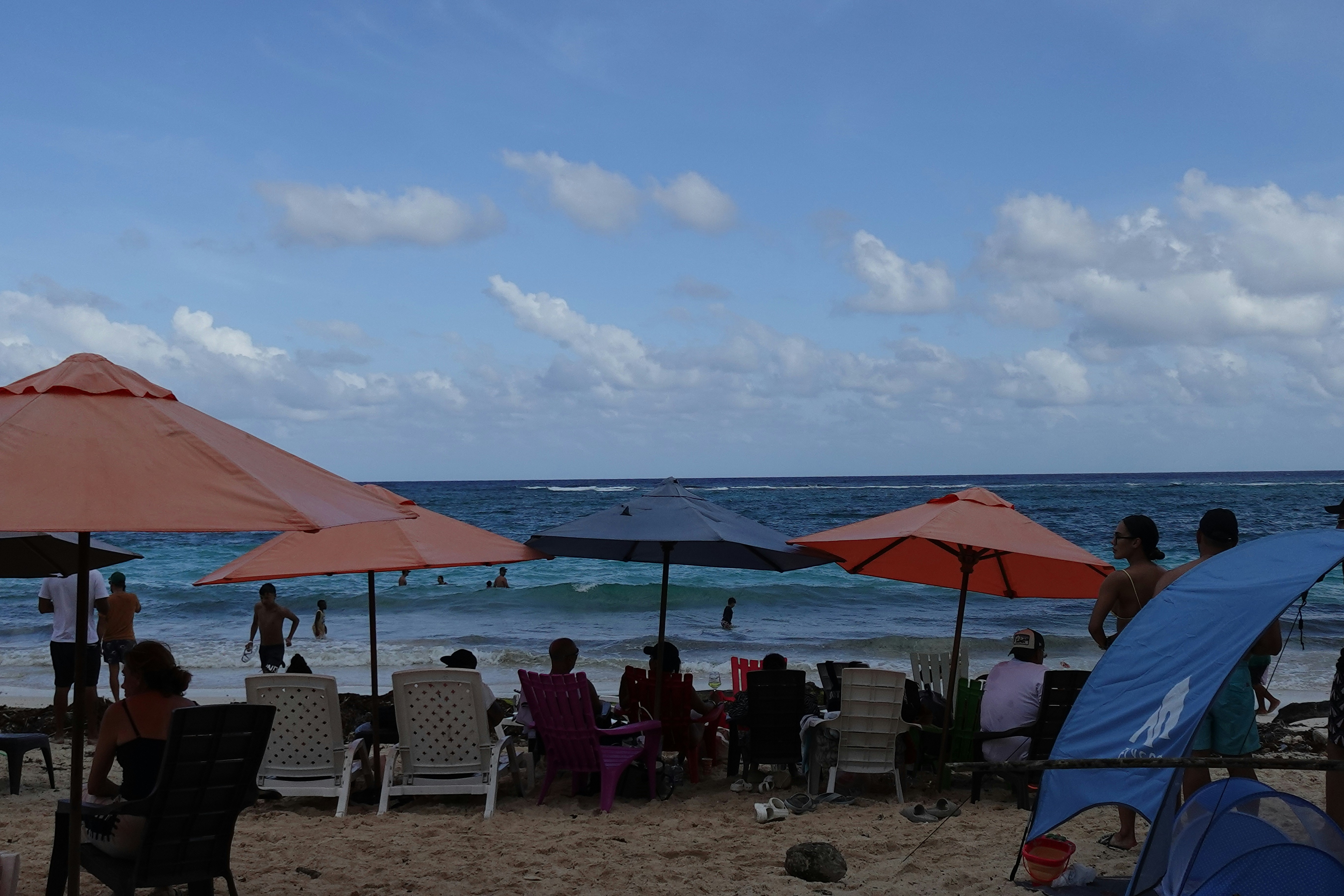 Sunlit Beach Café: Umbrellas, Chairs, and Ocean Horizon