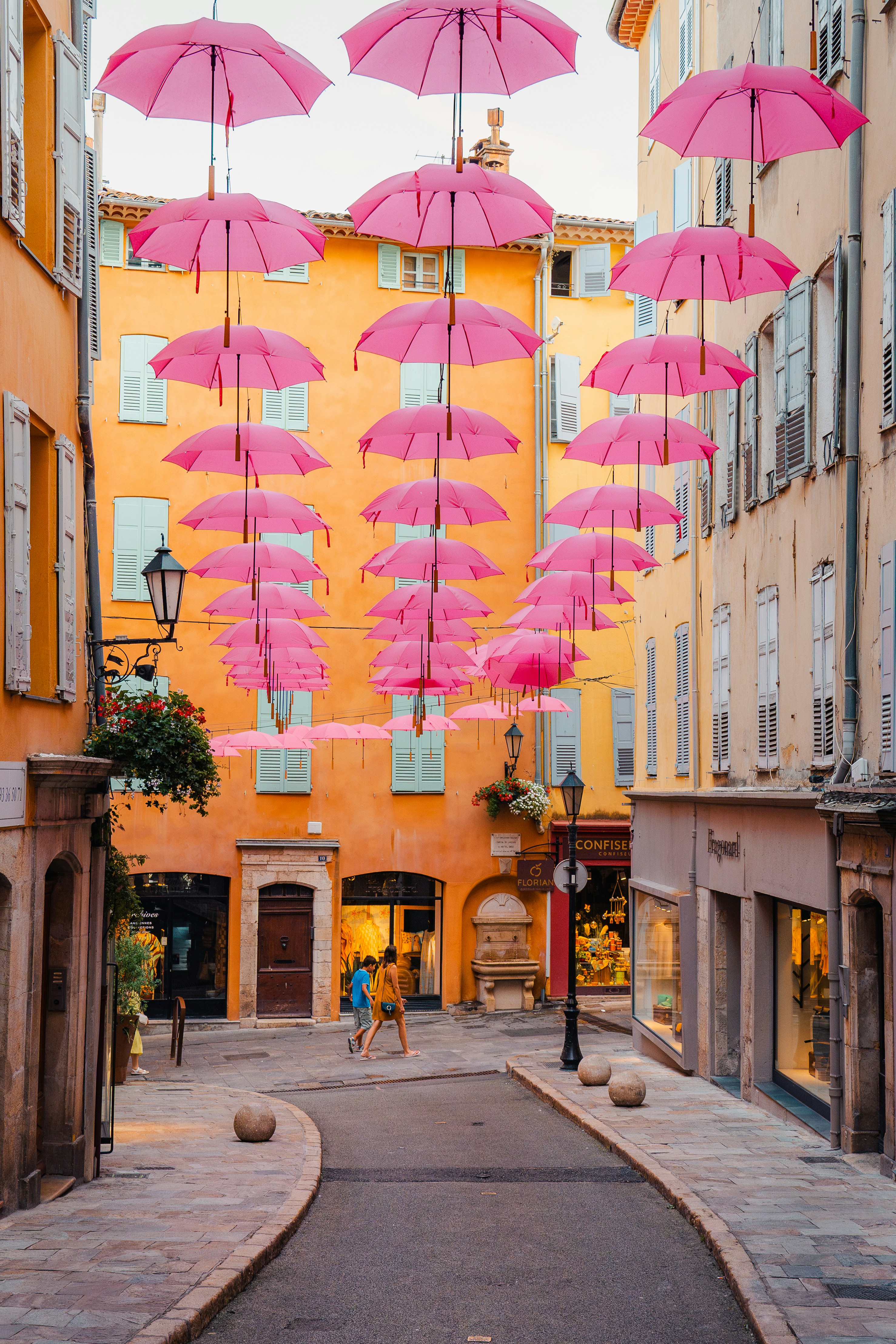 Pink Umbrella Sky Over a Mediterranean Street