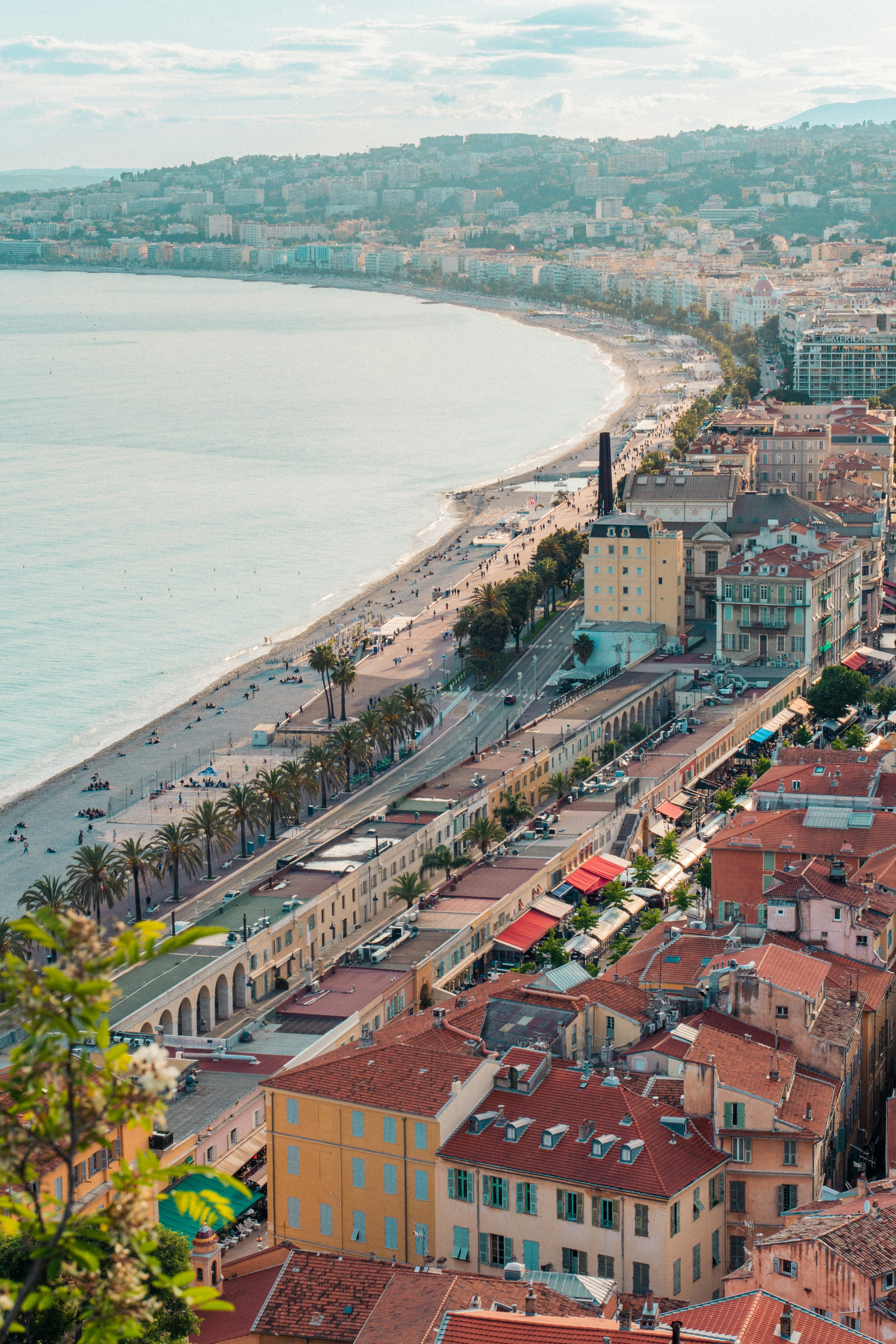Aerial Riviera: Terrace rooftops leading to a sunlit promenade along the coast