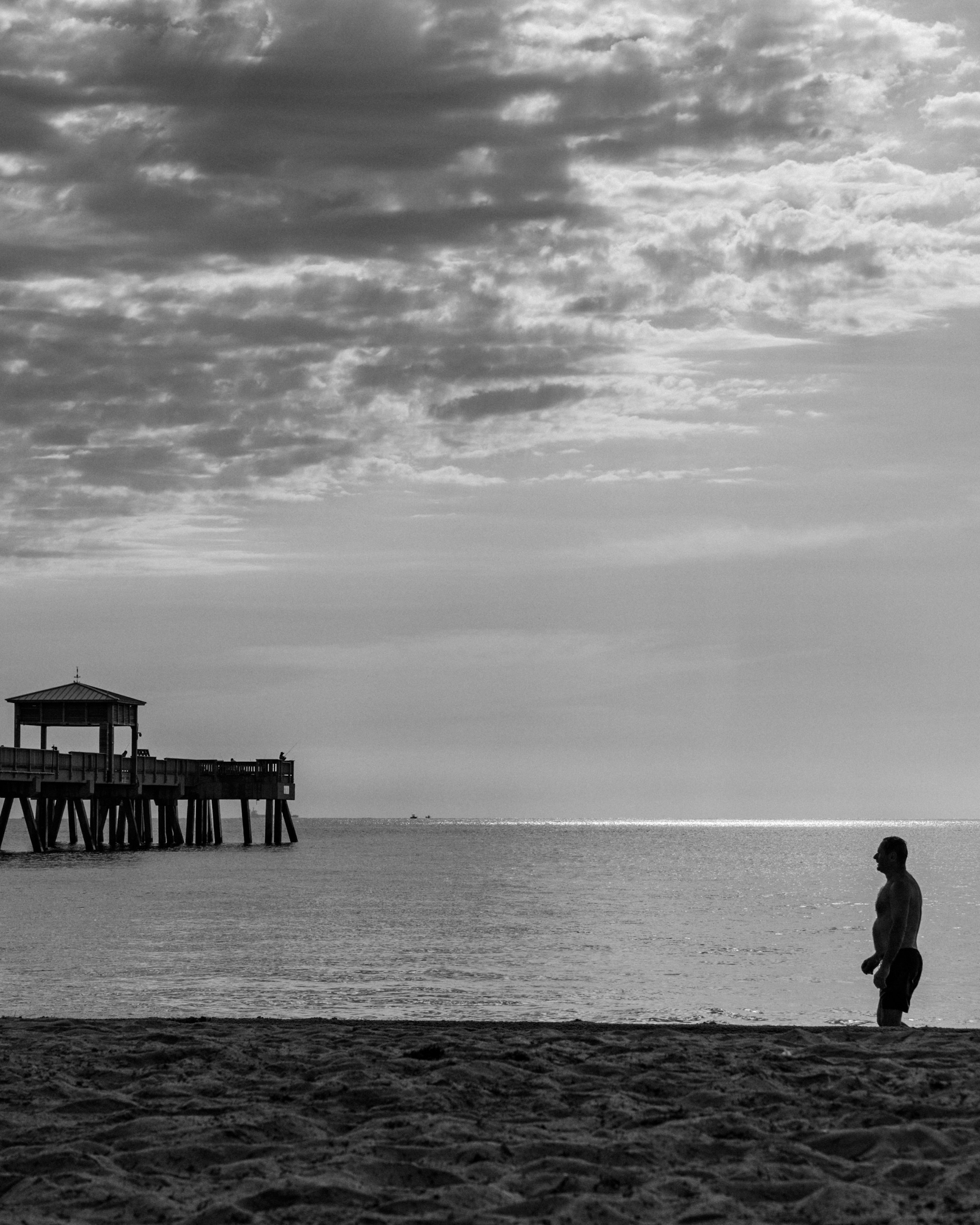 Silhouette at the Quiet Edge: A Lone Figure by the Pier