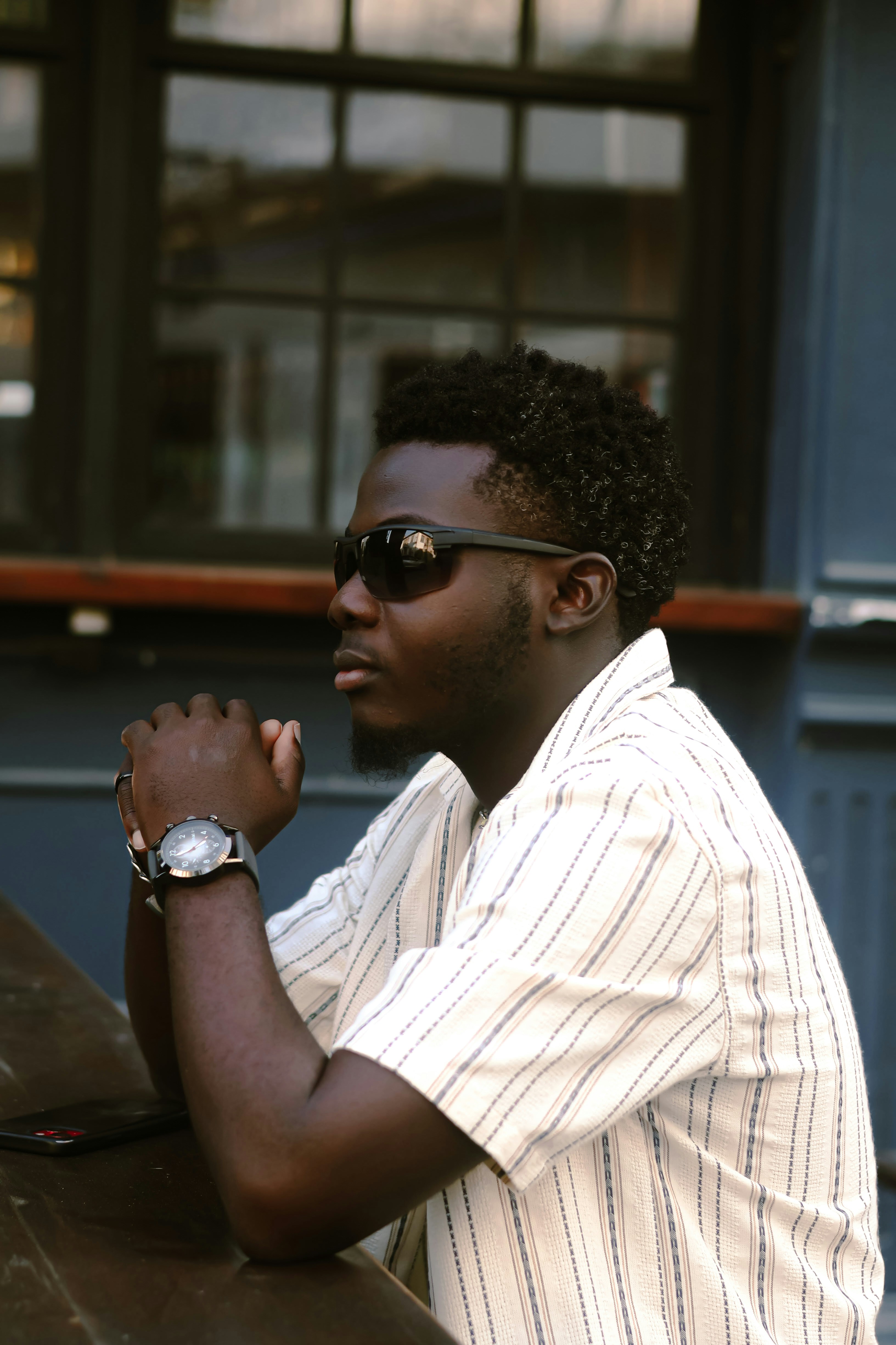 A man in sunglasses sits at a table outdoors.