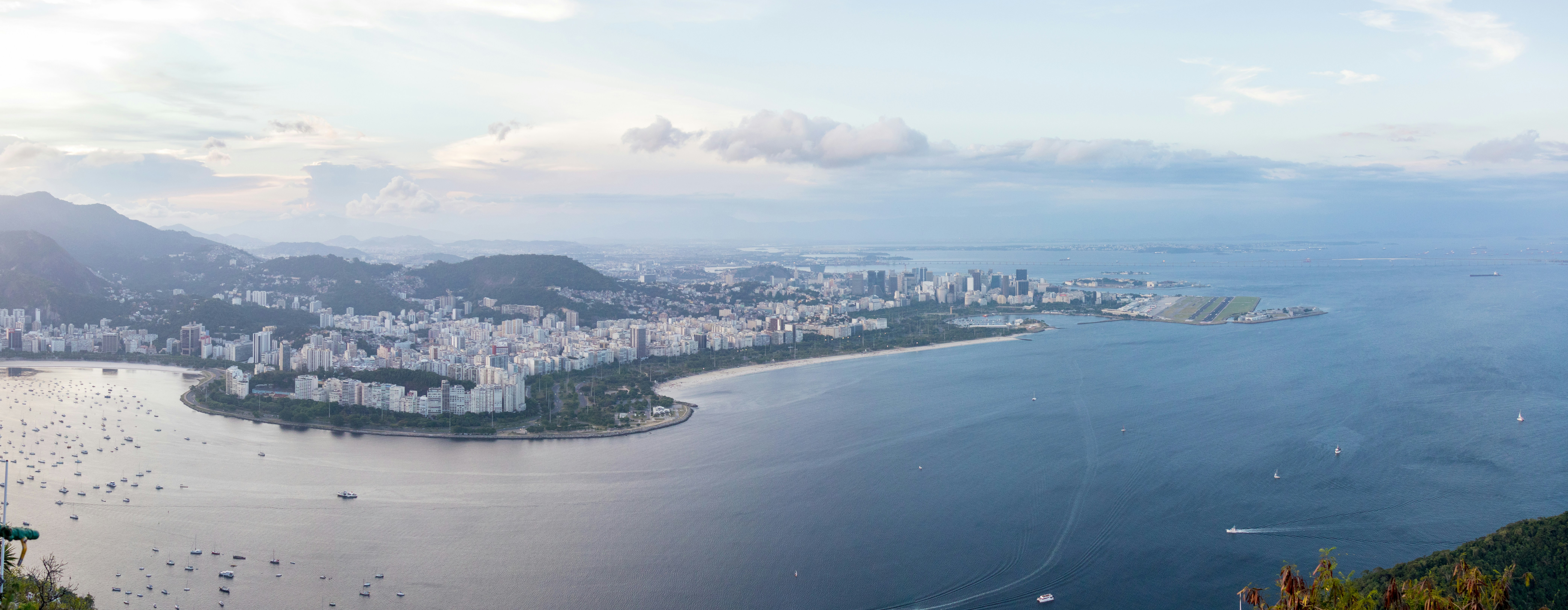 Panorama over a Coastal City: Aerial Hills Meet the Sapphire Sea
