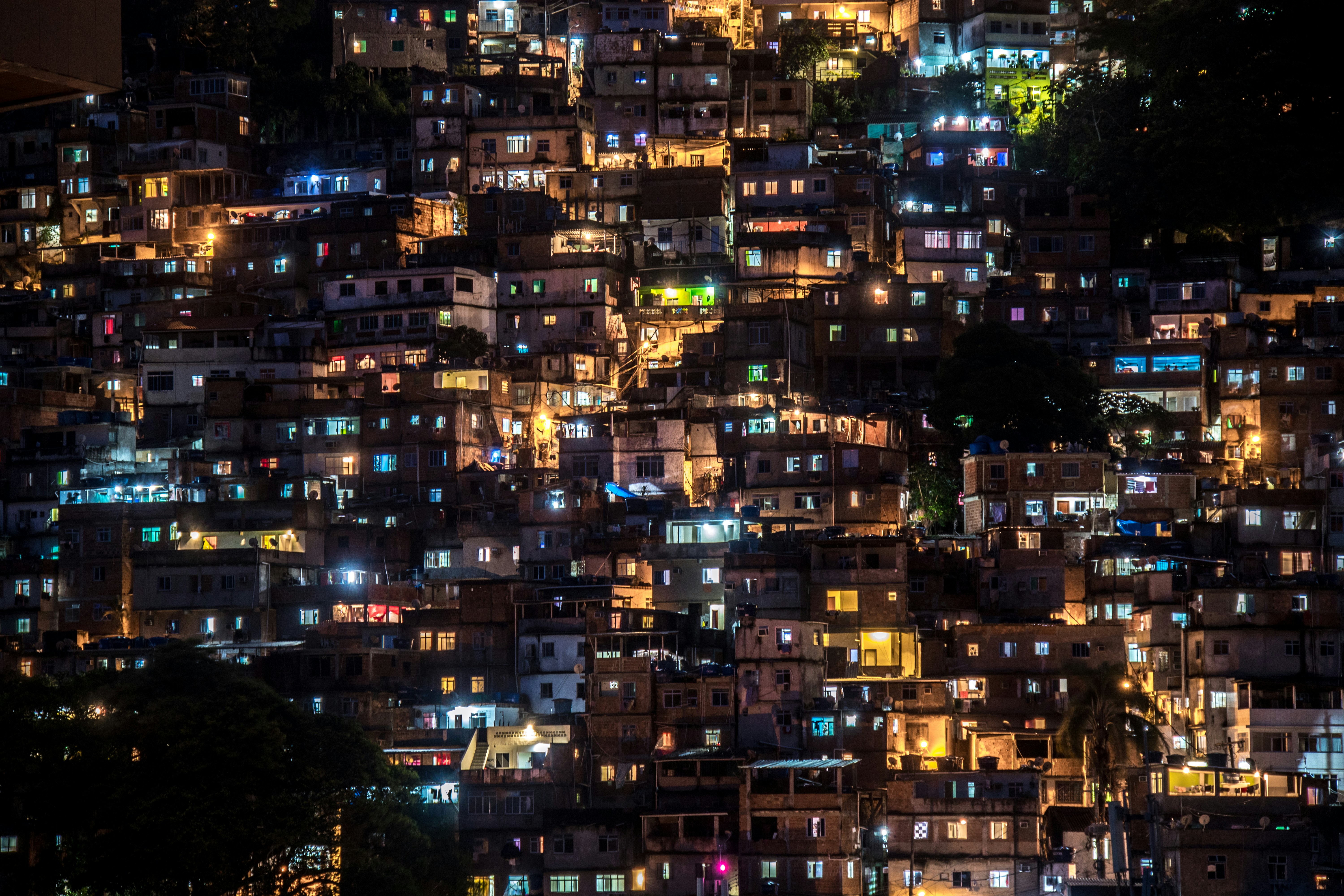A densely packed hillside city glows with lights at night.