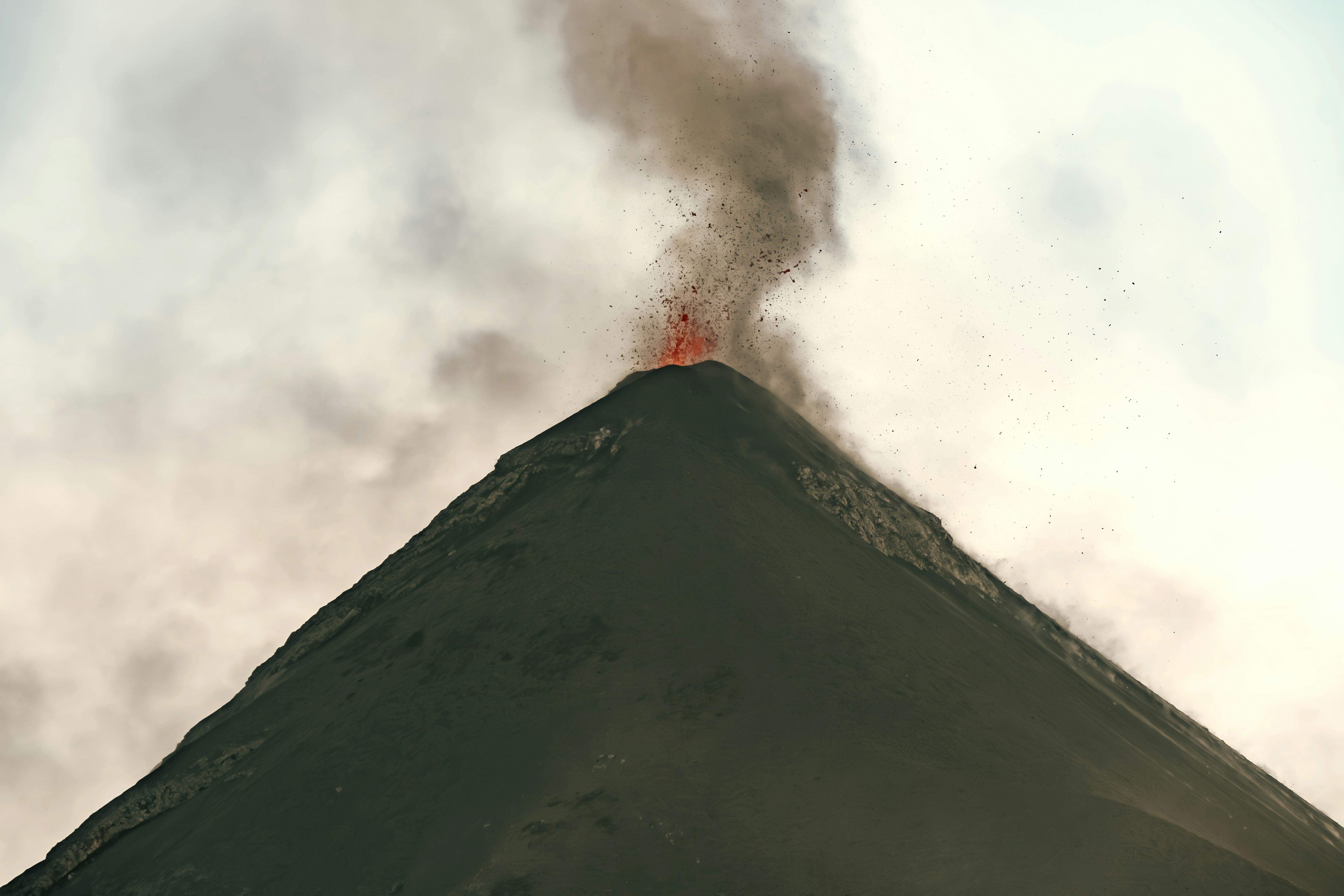 Cresting Inferno: A Volcanic Summit Exhaling Smoke and Fire