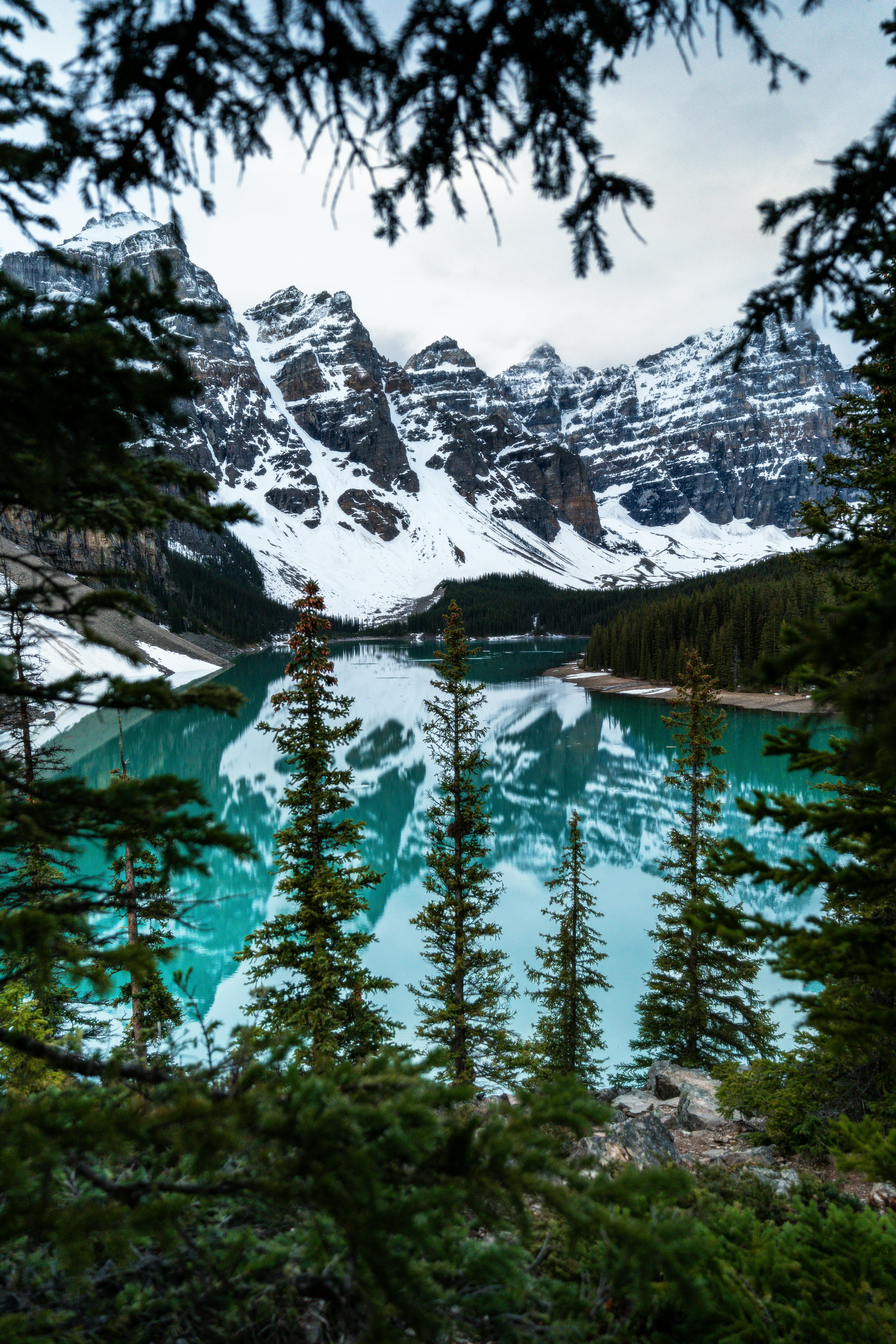 Emerald Lake Mirror: Snow‑Dust and Pine Framing a Mountain Ring