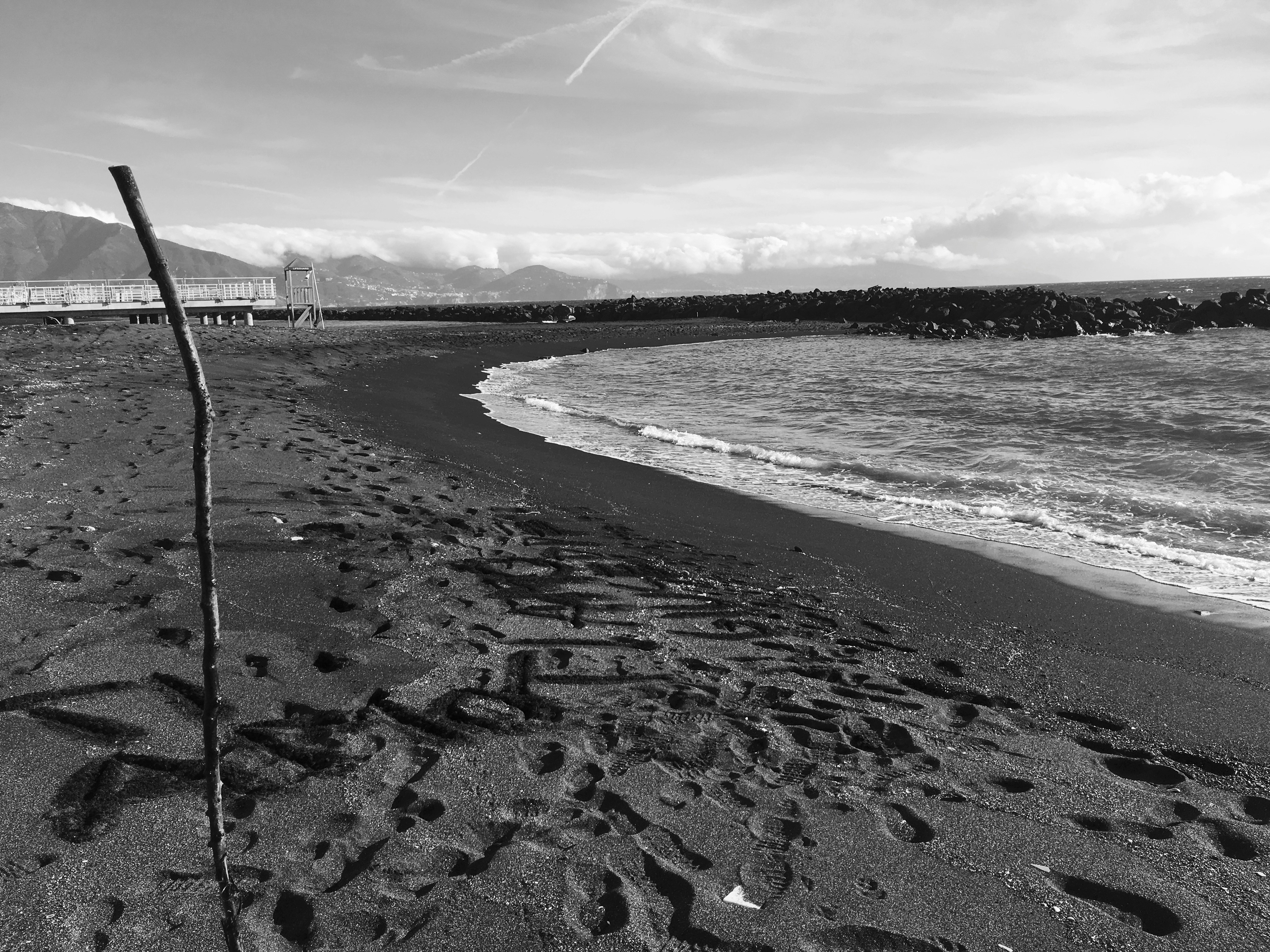 Footprints and shoreline at a windswept beach