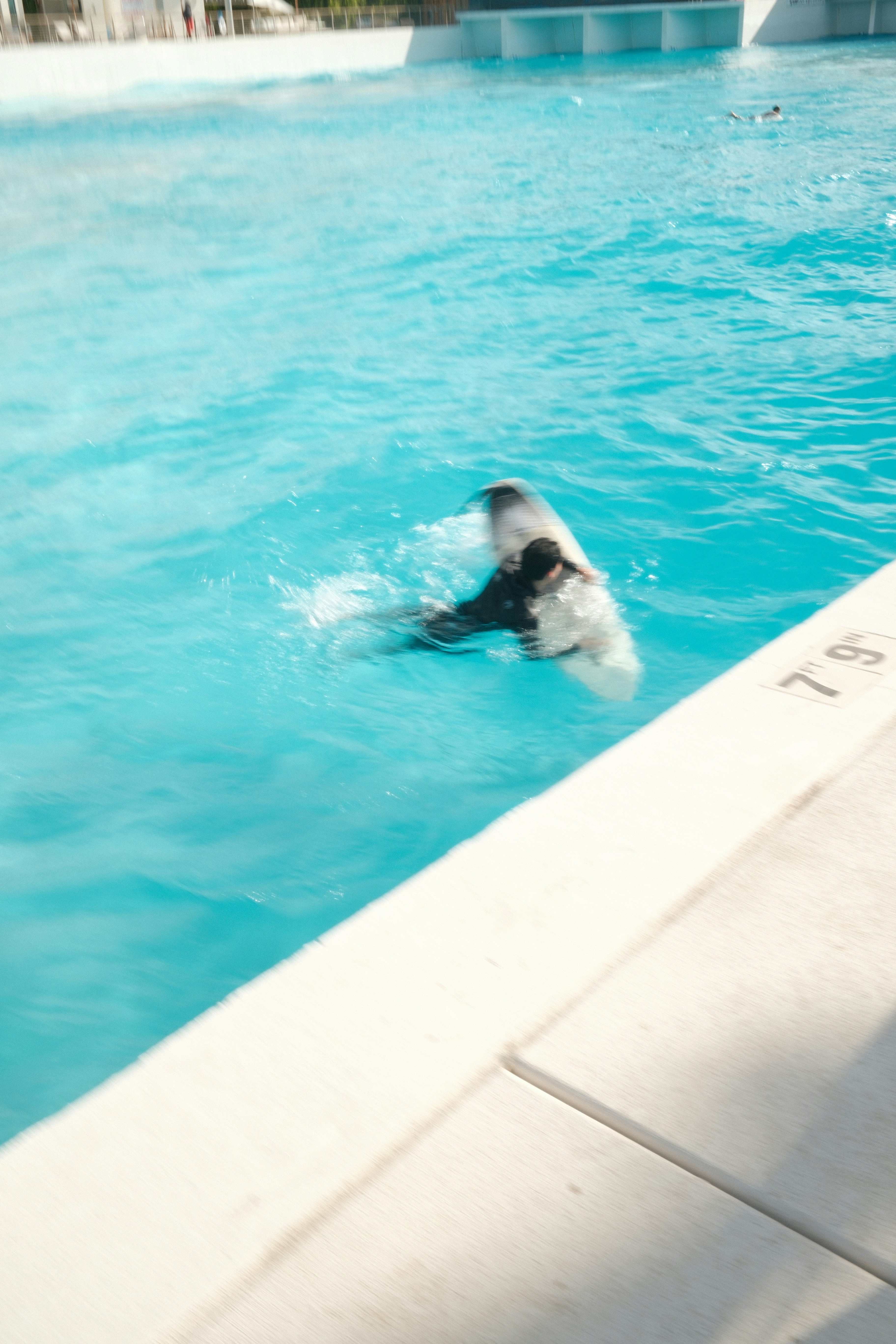 Someone swimming in a light blue pool.