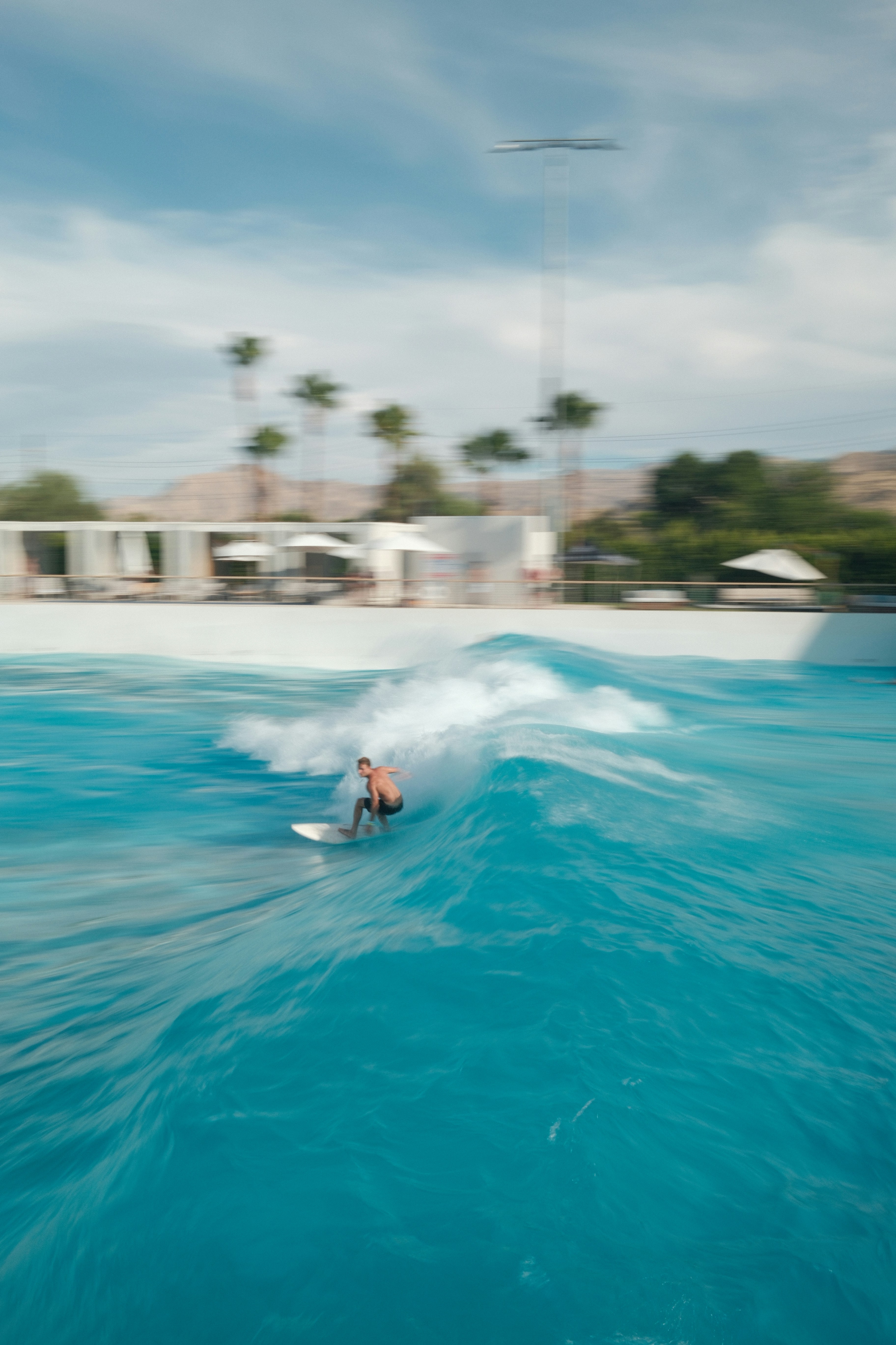 Surfing in the Blue Wake: A Blur of Motion Over a Public Pool