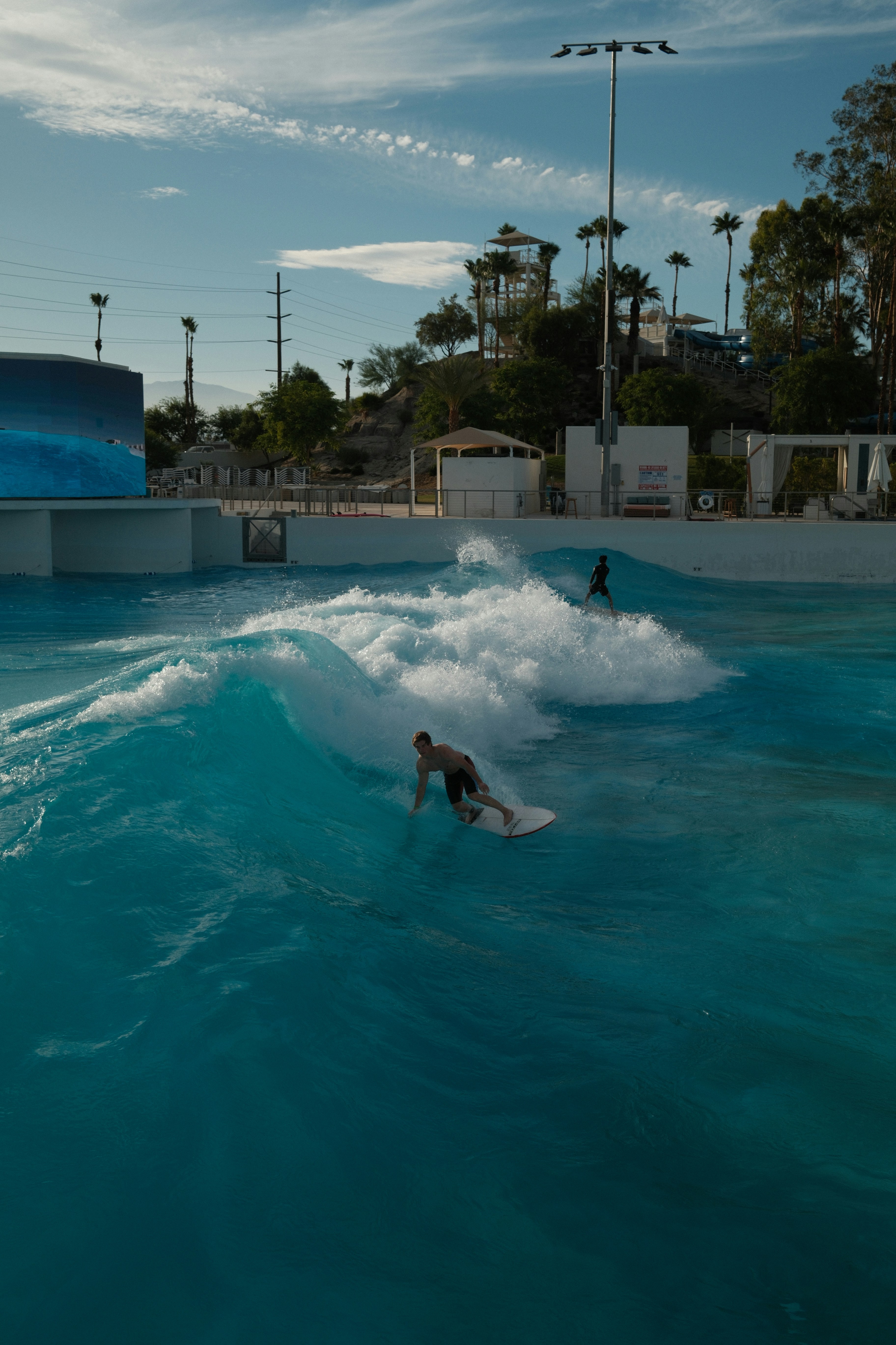 Surfer in turquoise tide at a sunny coastal wave park