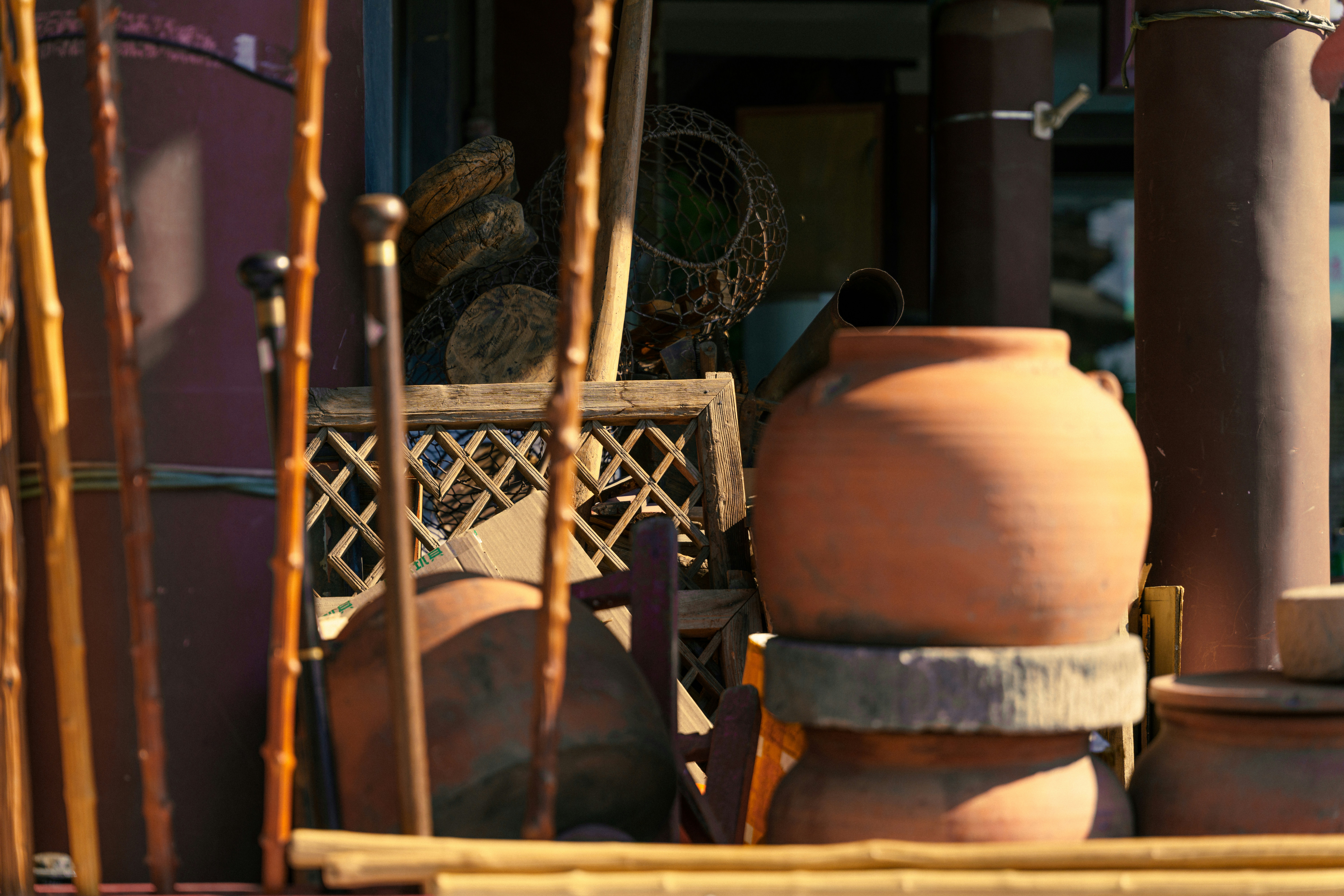 Large terracotta pot, wooden sticks, and rustic crafts.