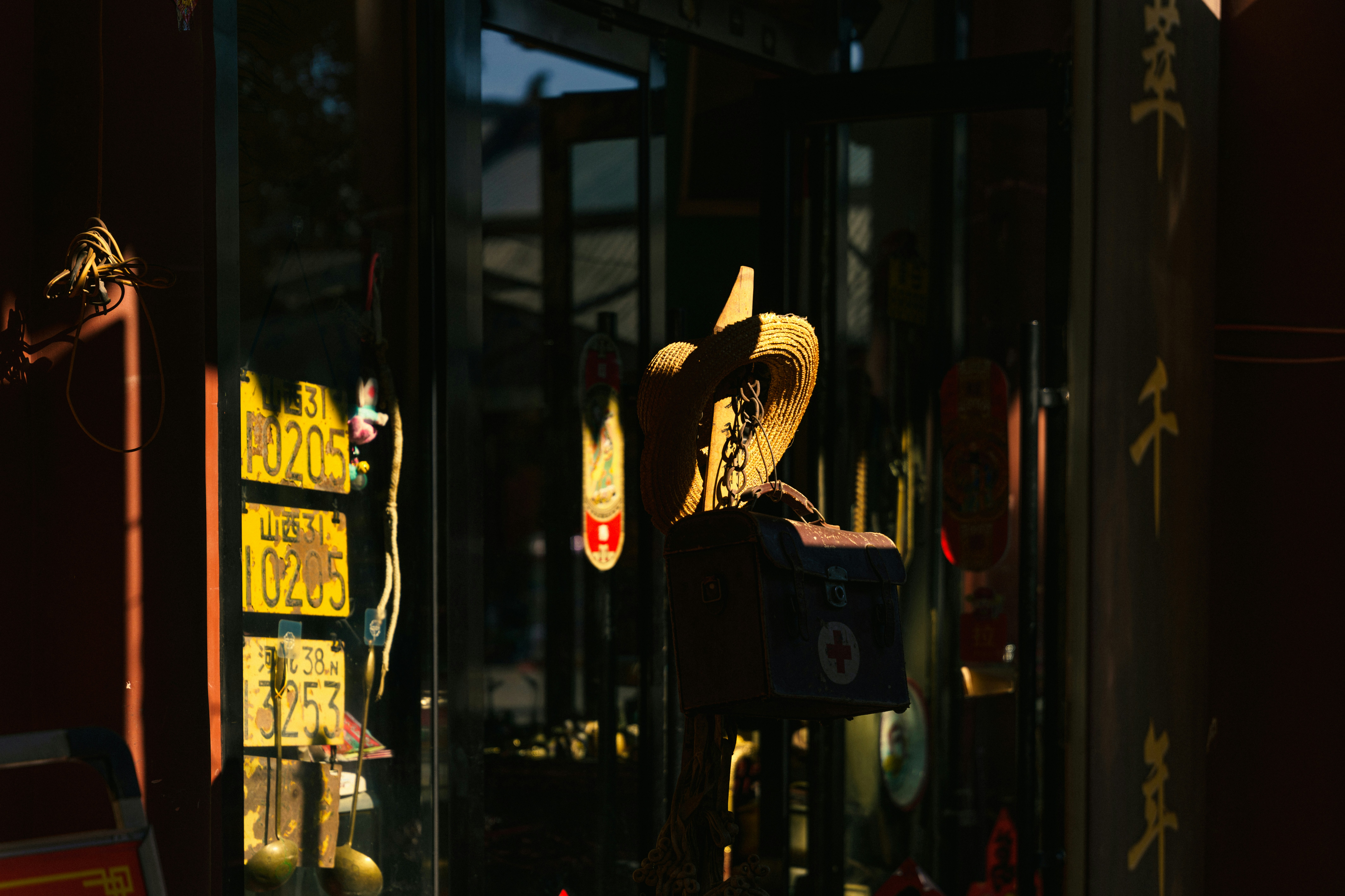 Stray straw hat and glowing storefronts: a nocturnal doorway scene