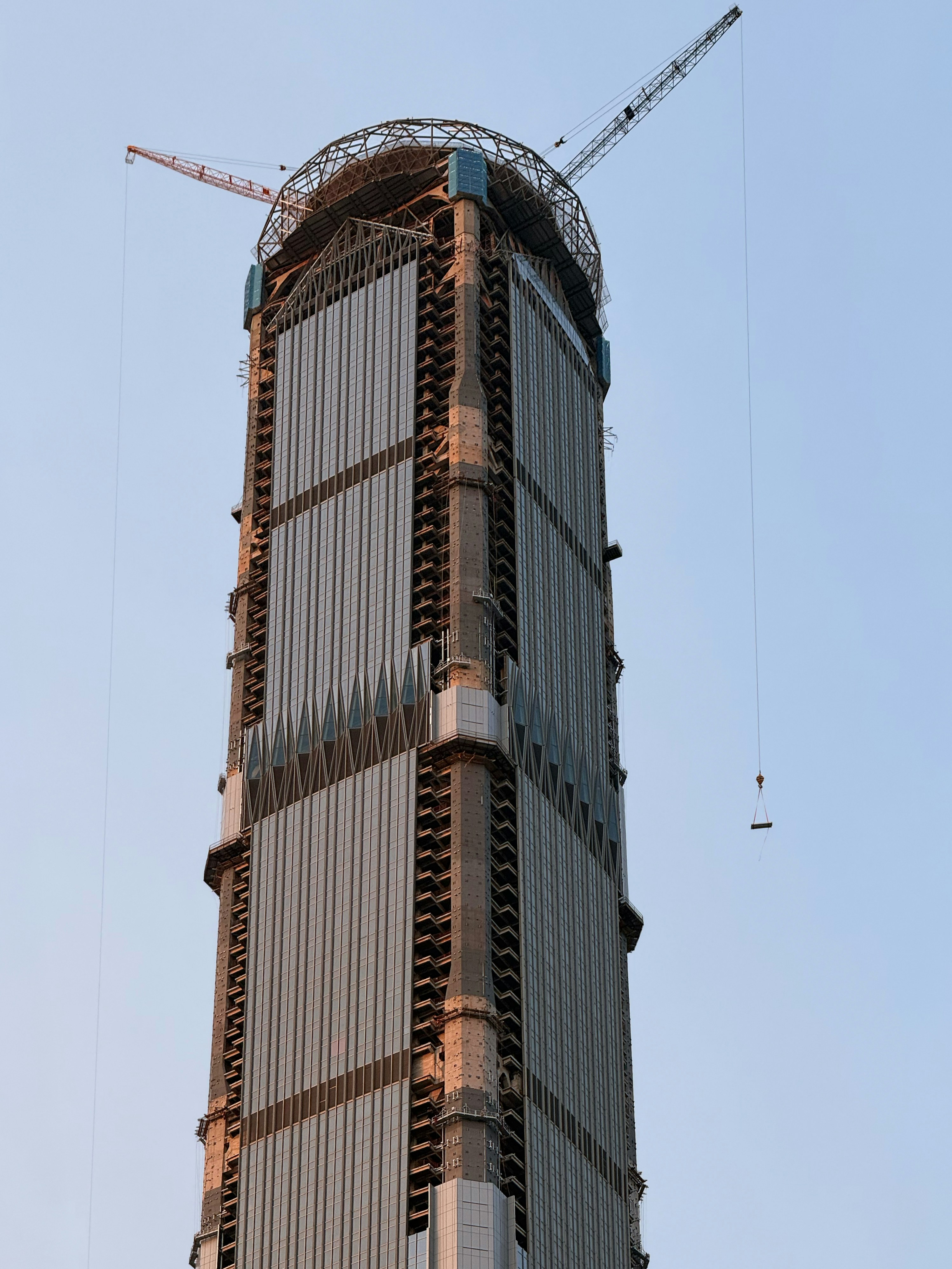 Tower of Time: Crane-Crowned Skyscraper Reaching the Sky