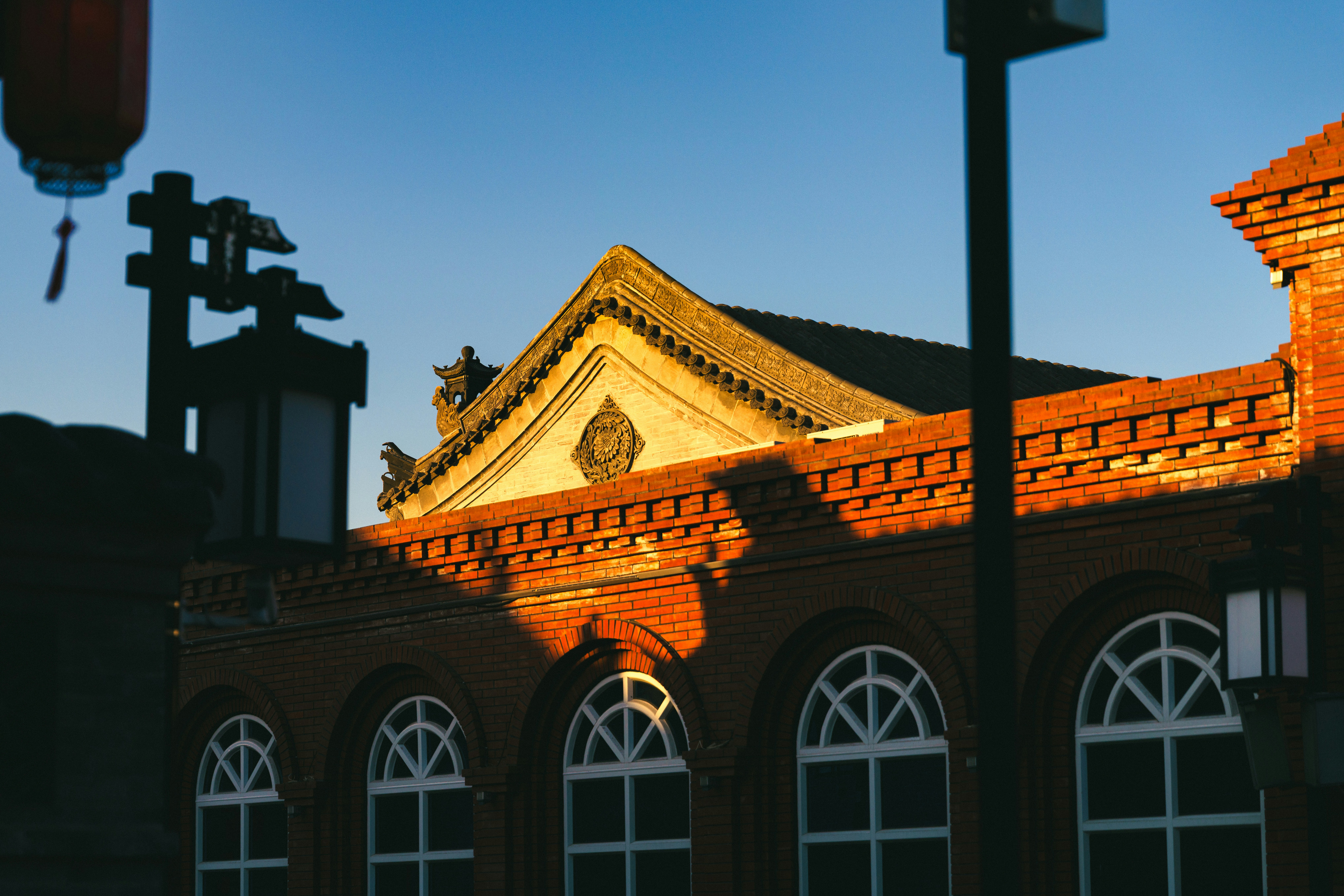 Sunlit Crest: Classic Brick Facade Under Evening Sky