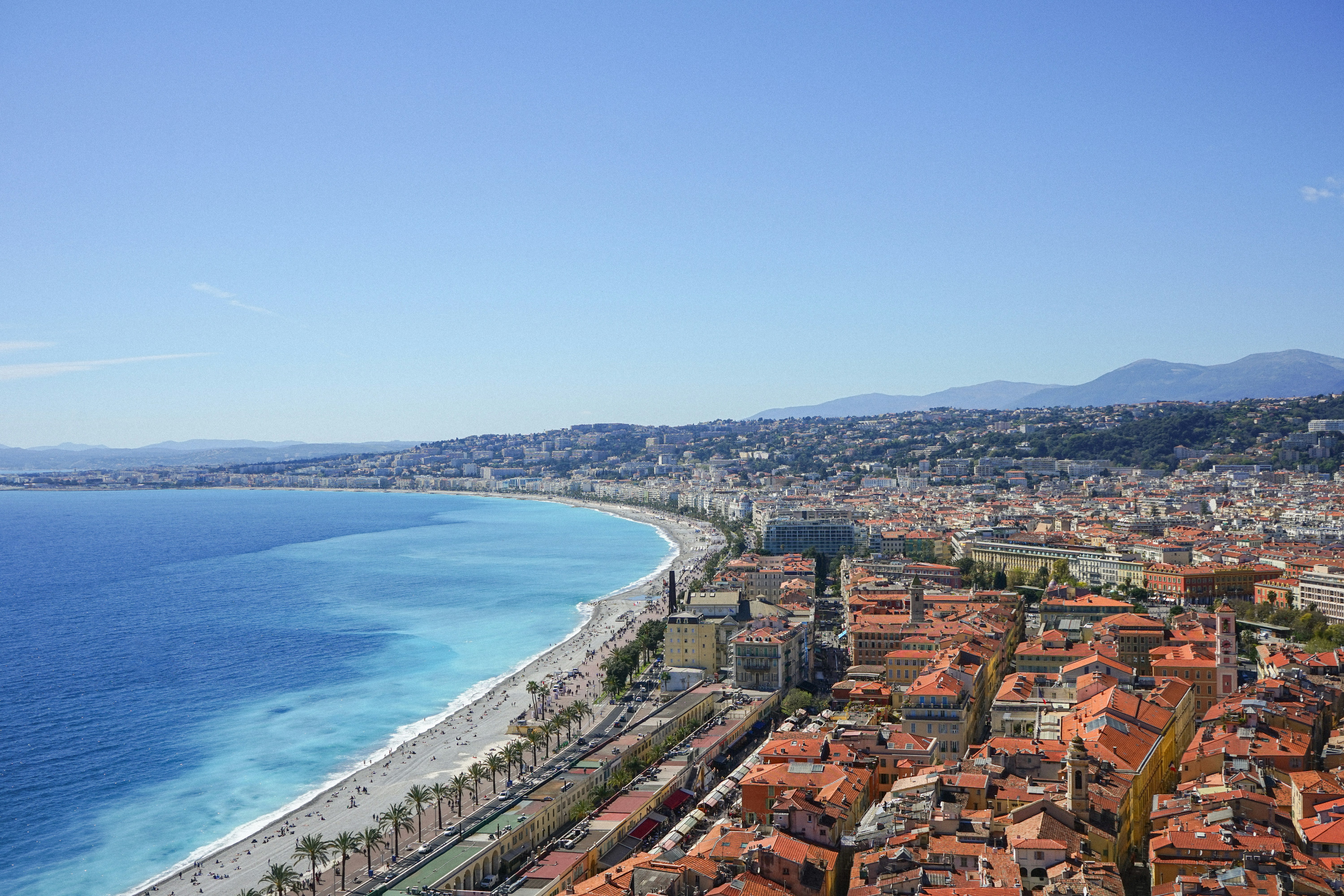 Coastal Panorama of a Sunlit Town Wrapped by Turquoise Waters