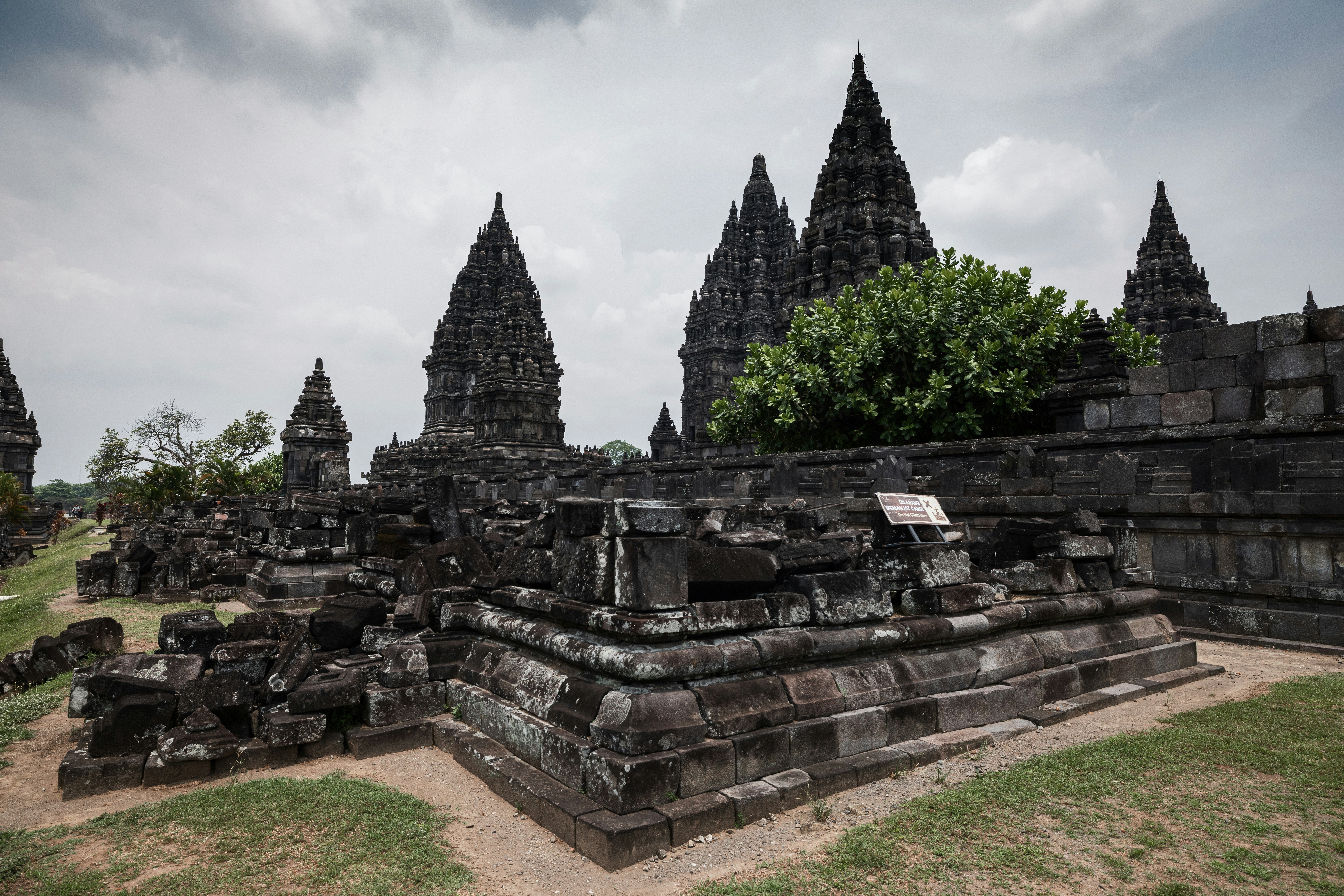 Ancient stone temples and ruins under a cloudy sky.