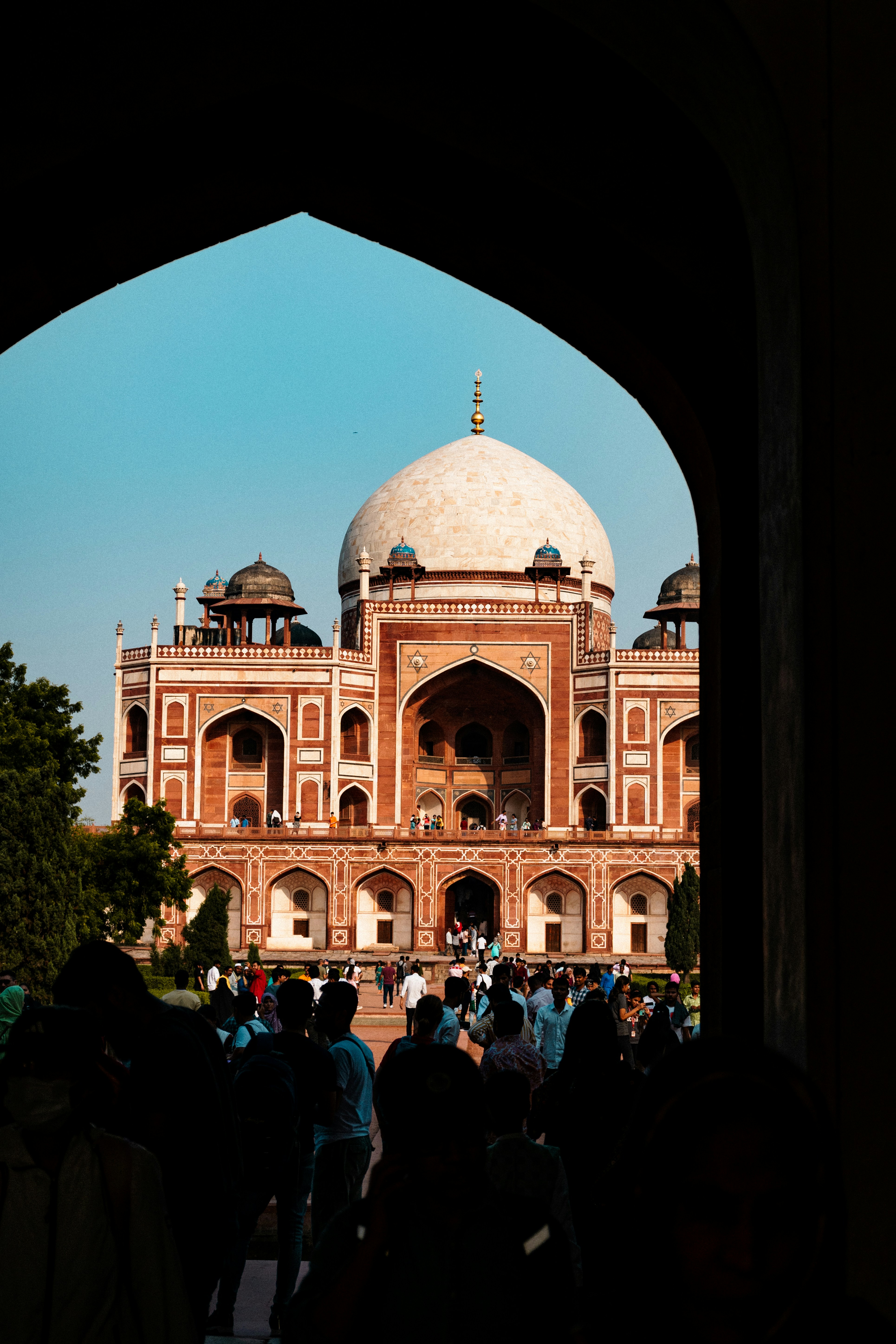 Gateway to the Taj: a silhouette frames the red sandstone facade under a blue sky