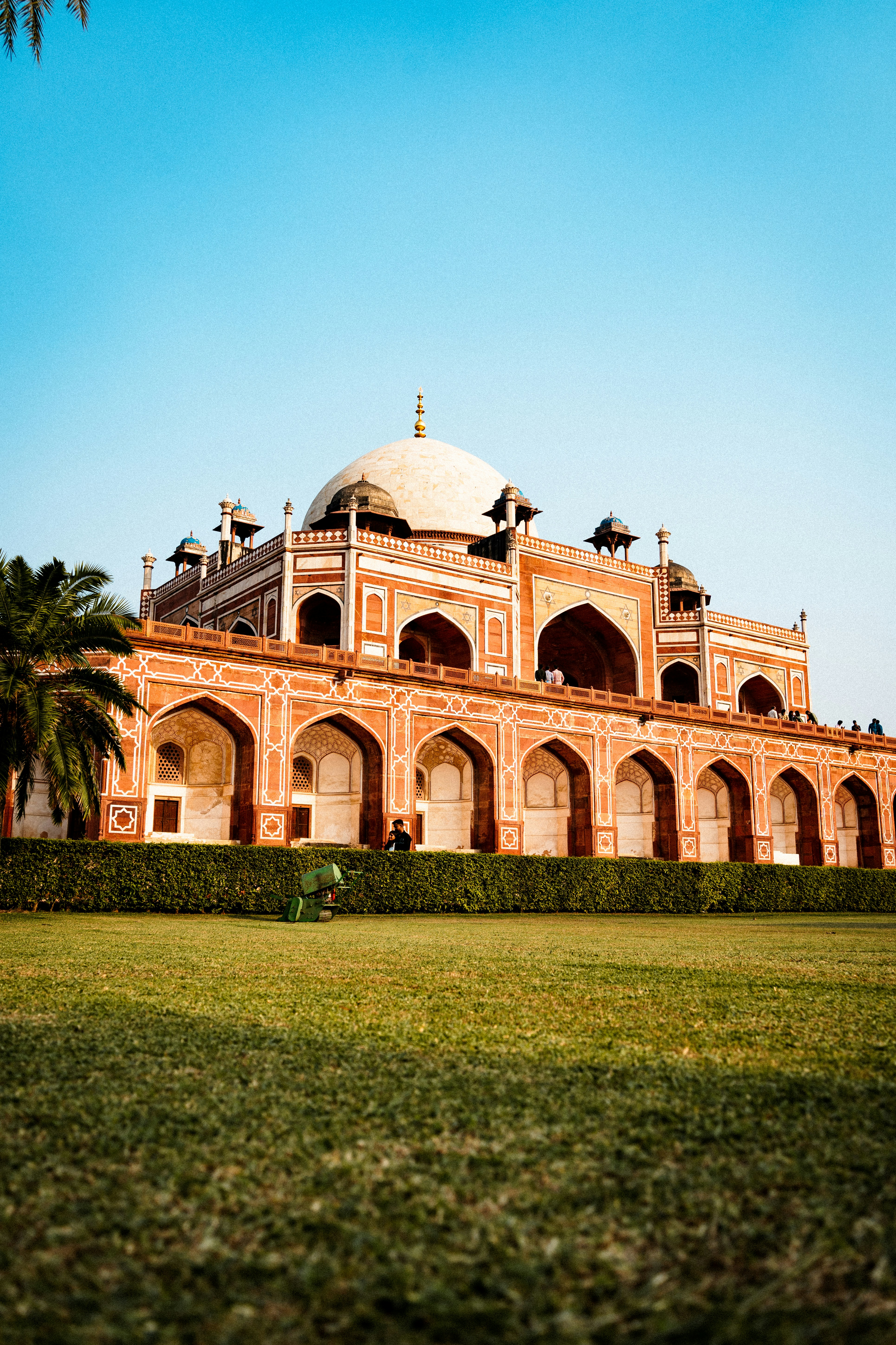 Dome and Arches: A Sunlit Mughal Facade Rising Over a Velvet Lawn