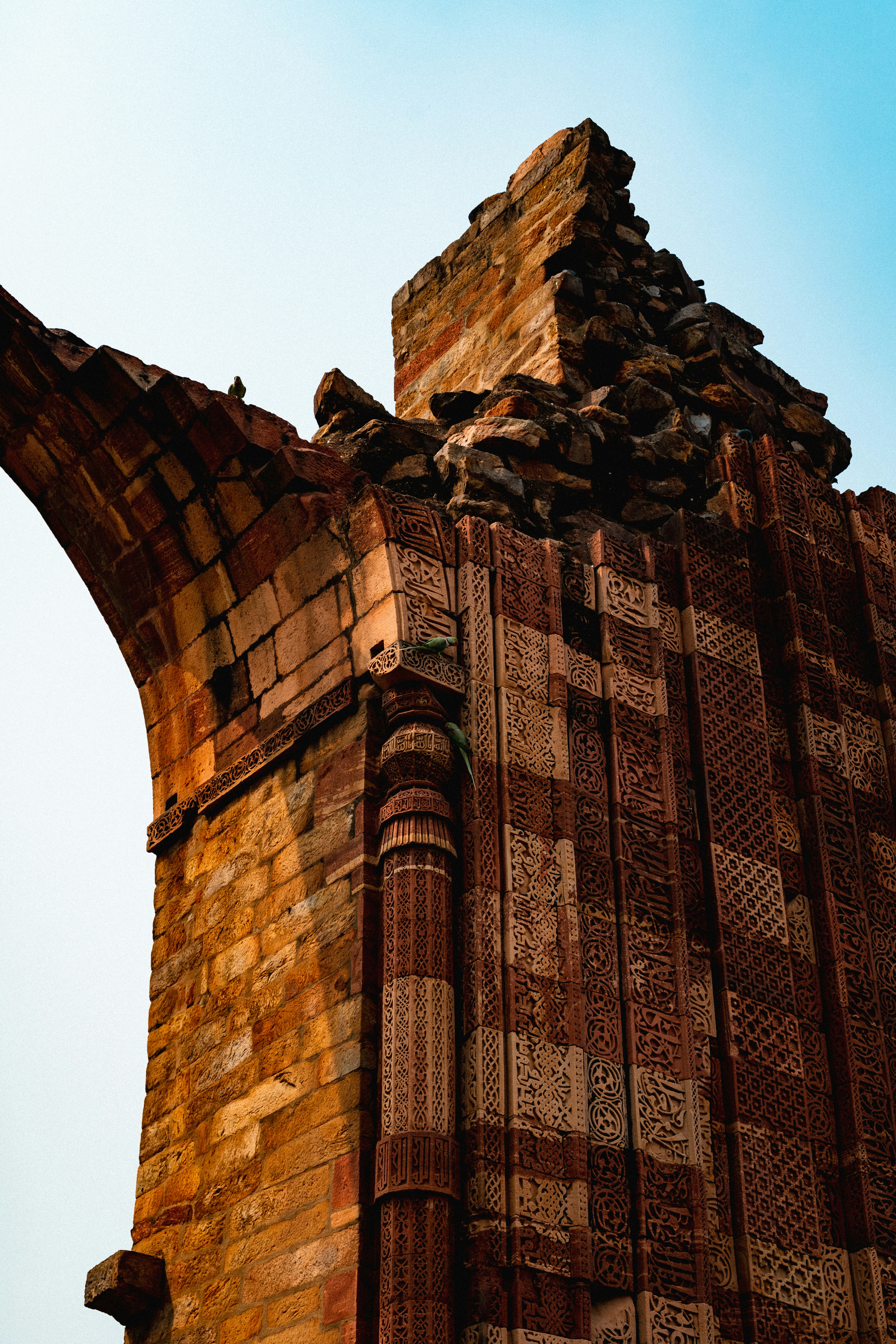 Ancient red sandstone archway ruins against a light sky.