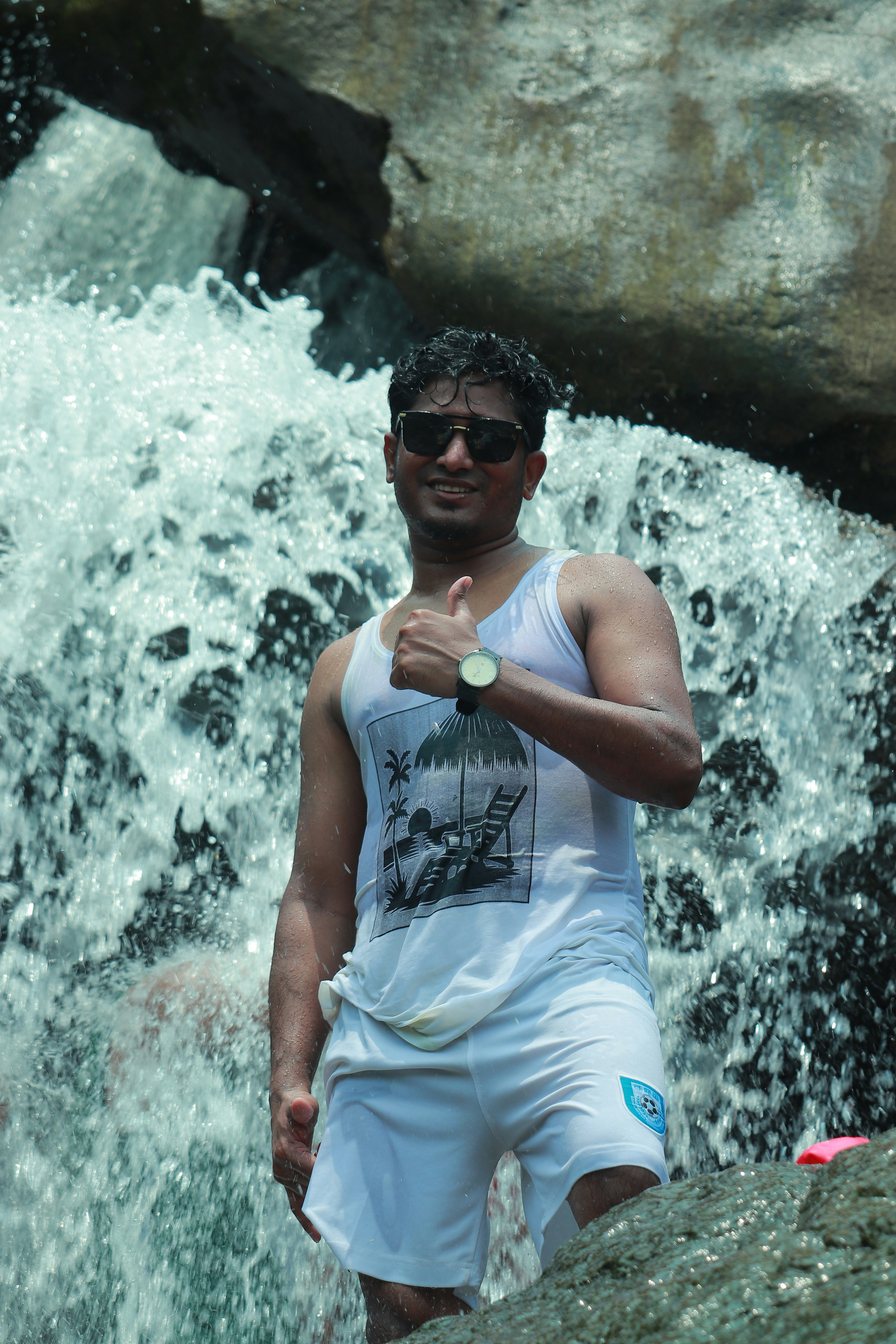 Thumbs Up in the Cascading Shower: A Sunlit Moment by the Falls