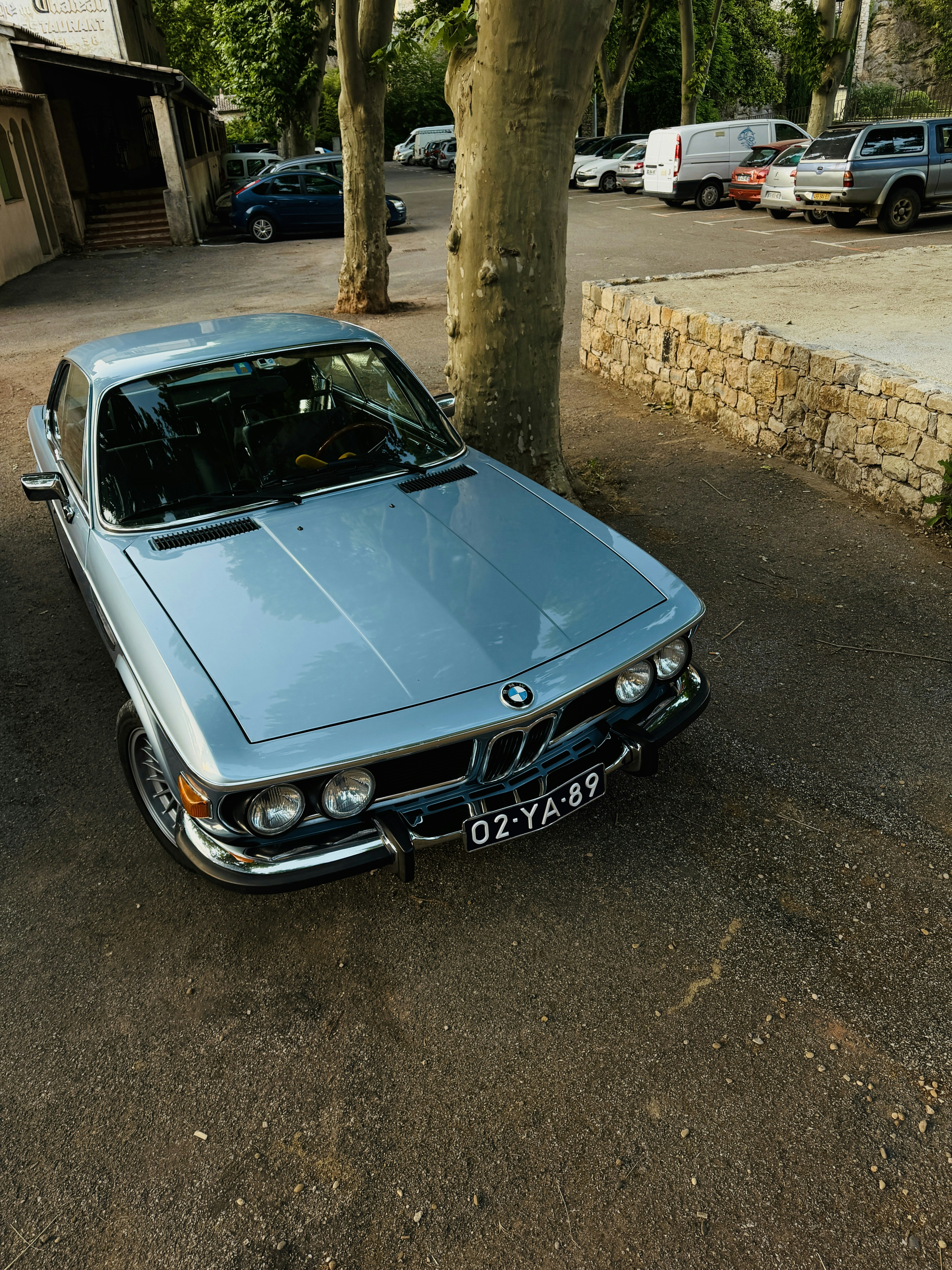 Blue classic BMW under a tree: vintage lines and chrome details