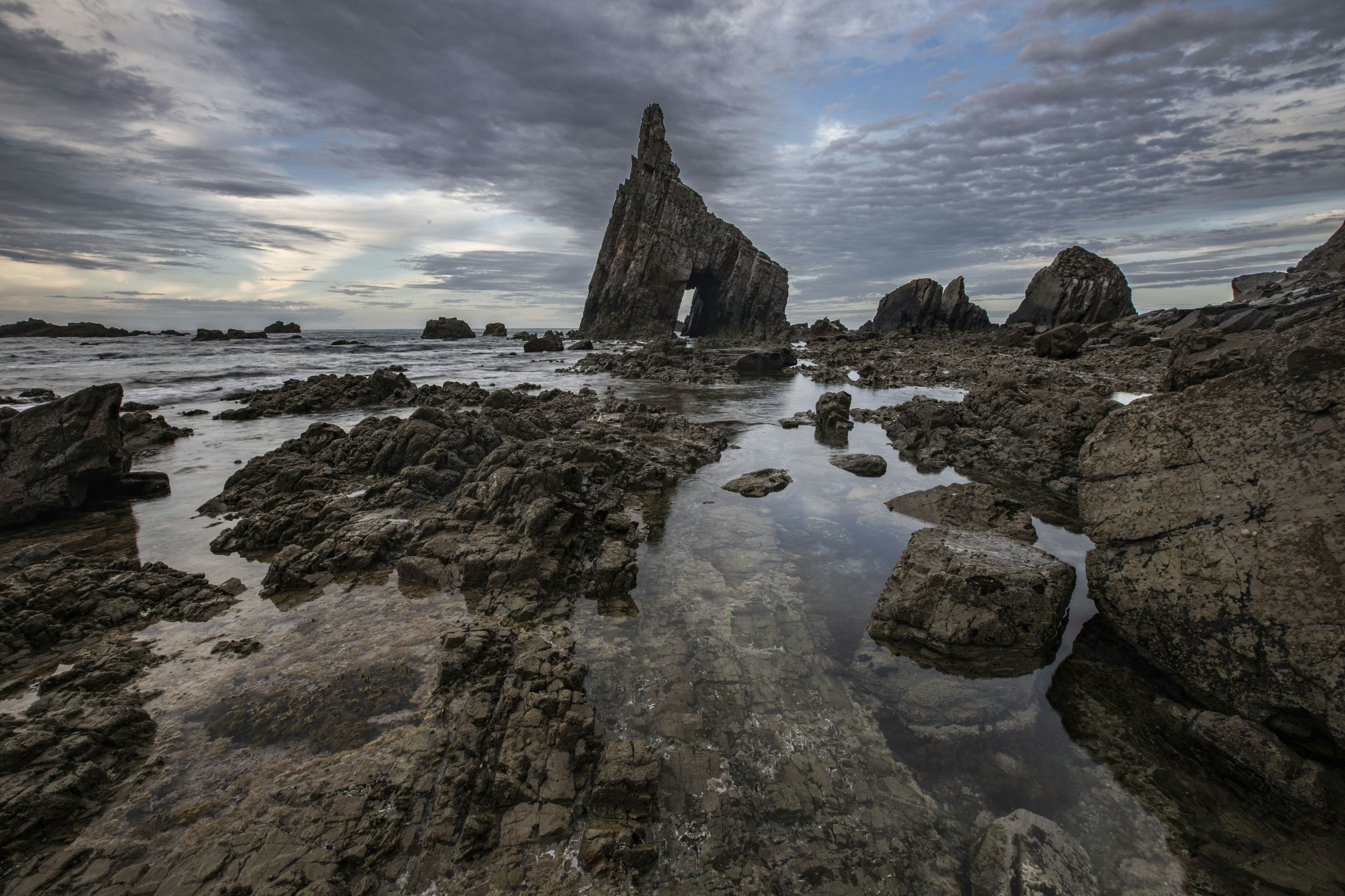 Sea-arched Sentinel: A jagged rock gateway in a tidal mosaic
