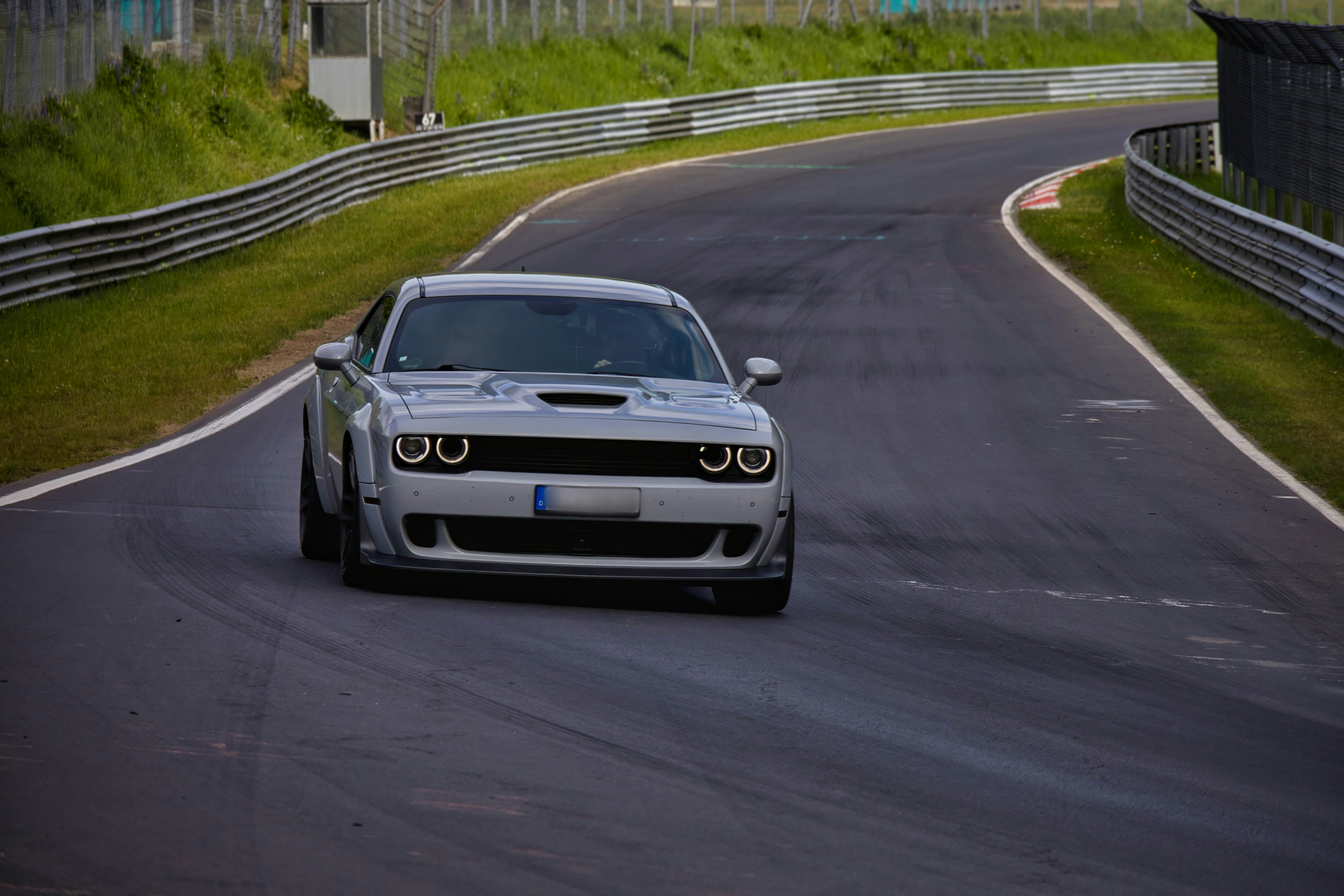 Chrome on the Curves: A silver muscle car wrestles a sunlit track