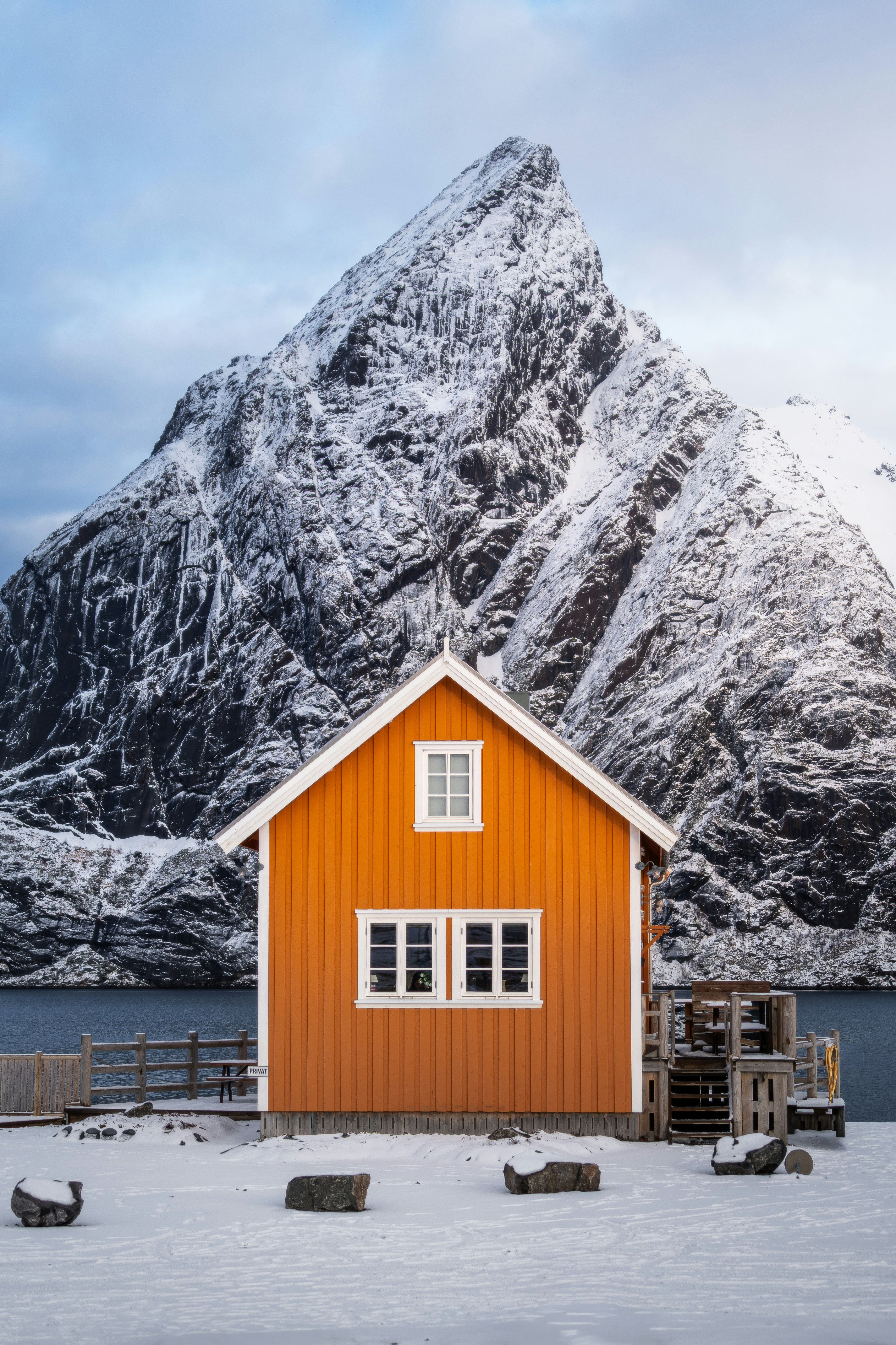 Orange House at the Foot of a Snow‑Dusted Peak