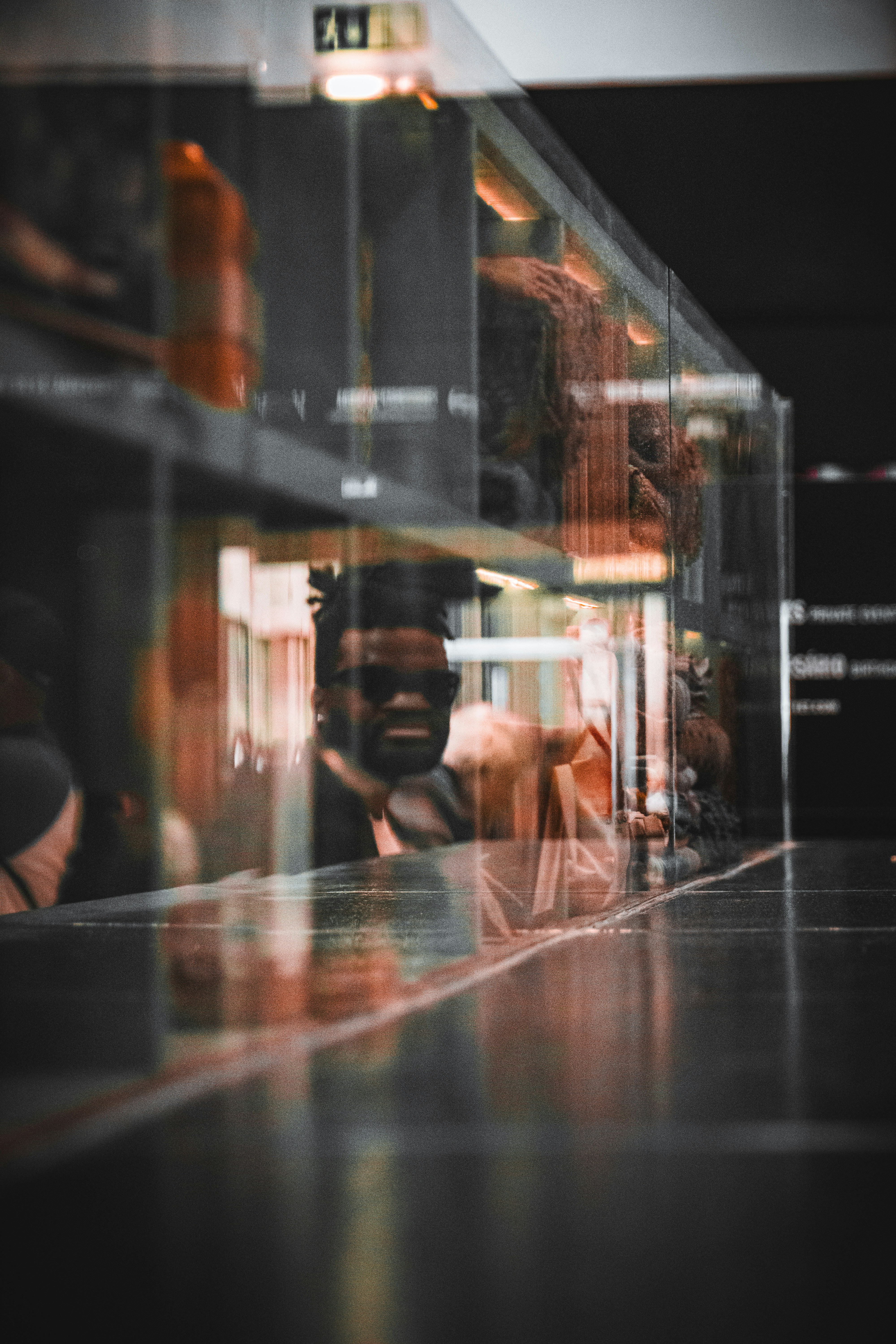 Reflections Behind Glass: A Corridor of Echoed Faces
