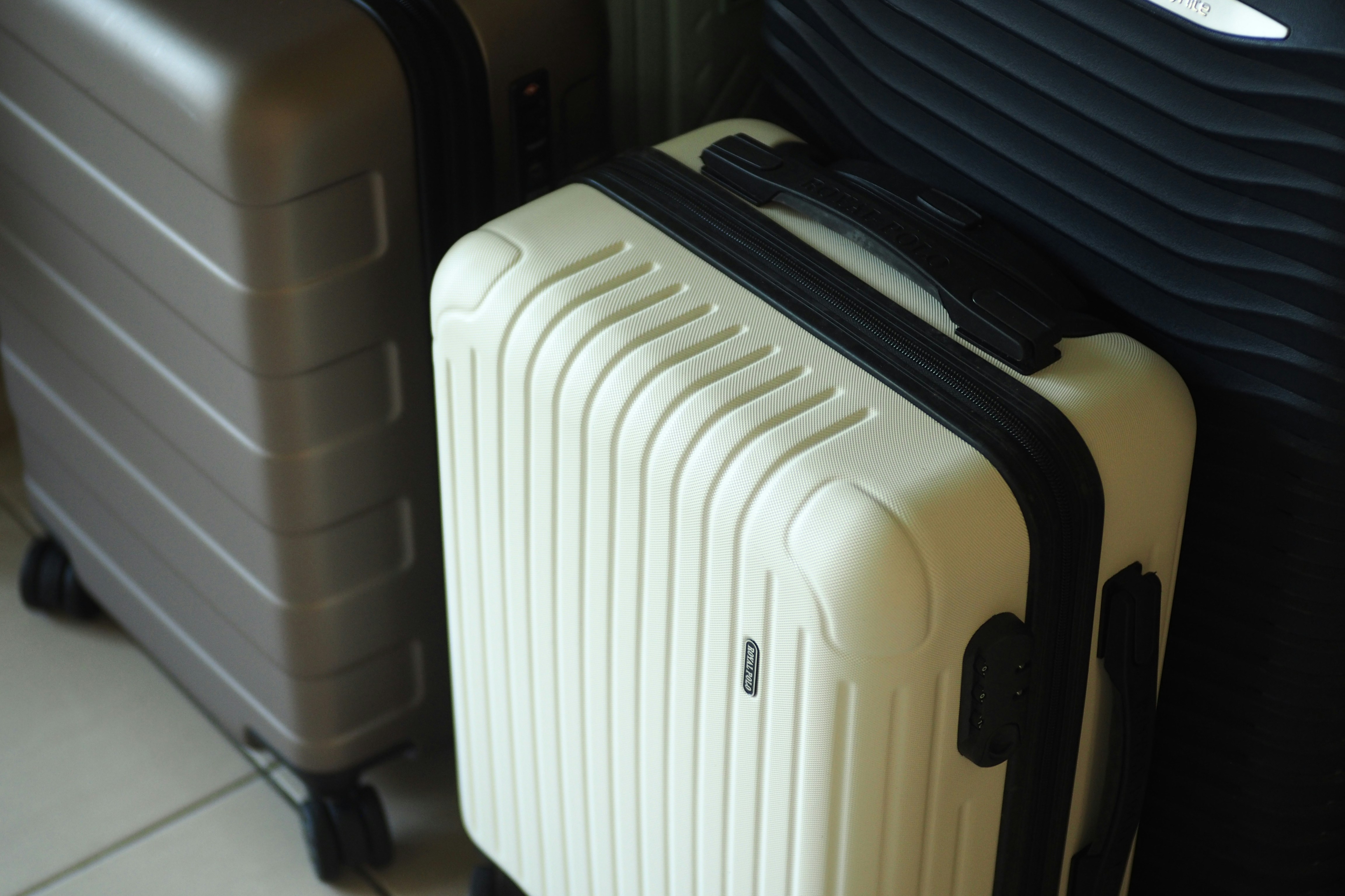 Cream-colored Carry-On Among Giant Luggage